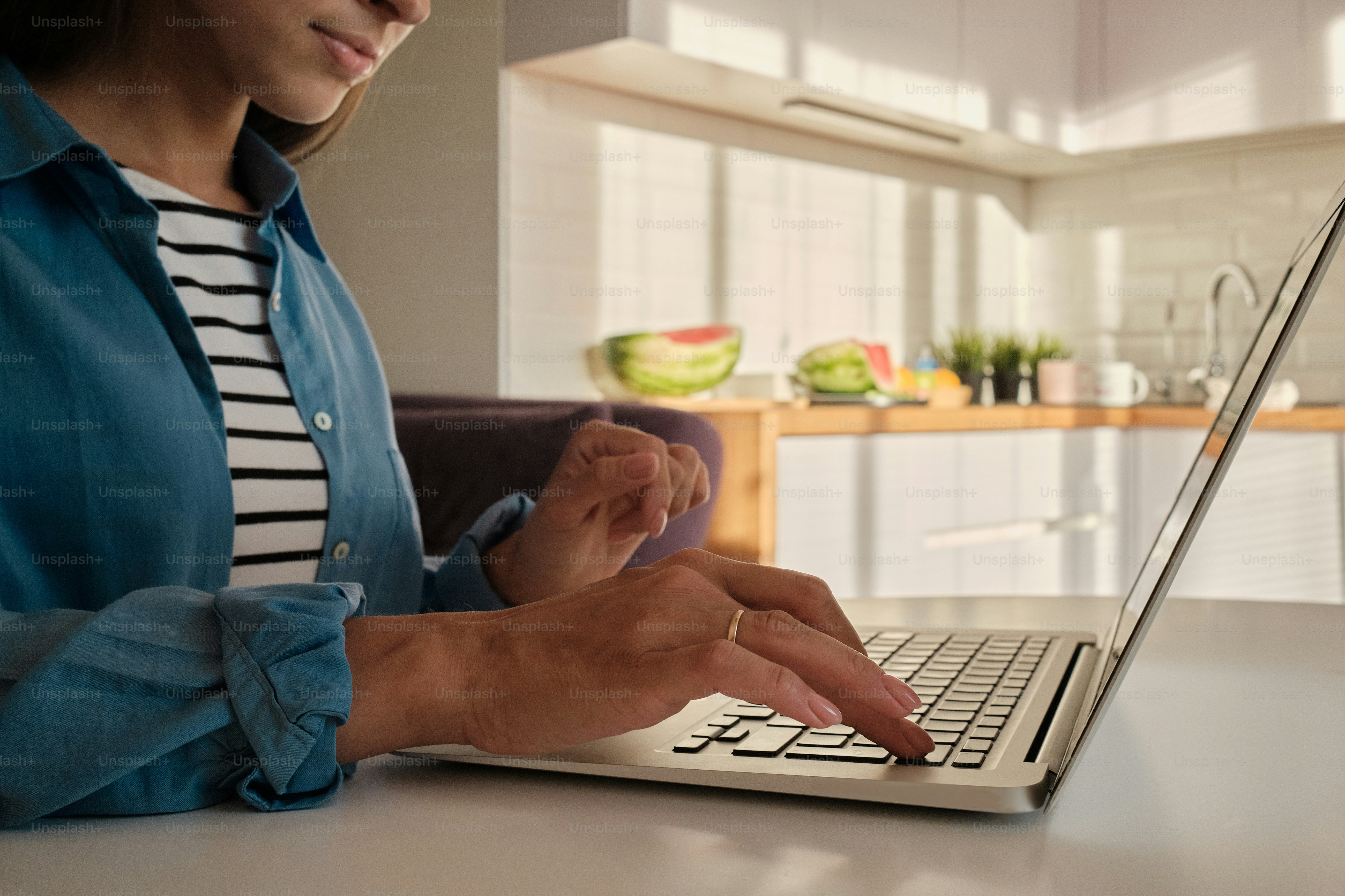 A woman sitting at a table using a laptop computer photo – Wfh Image on ...