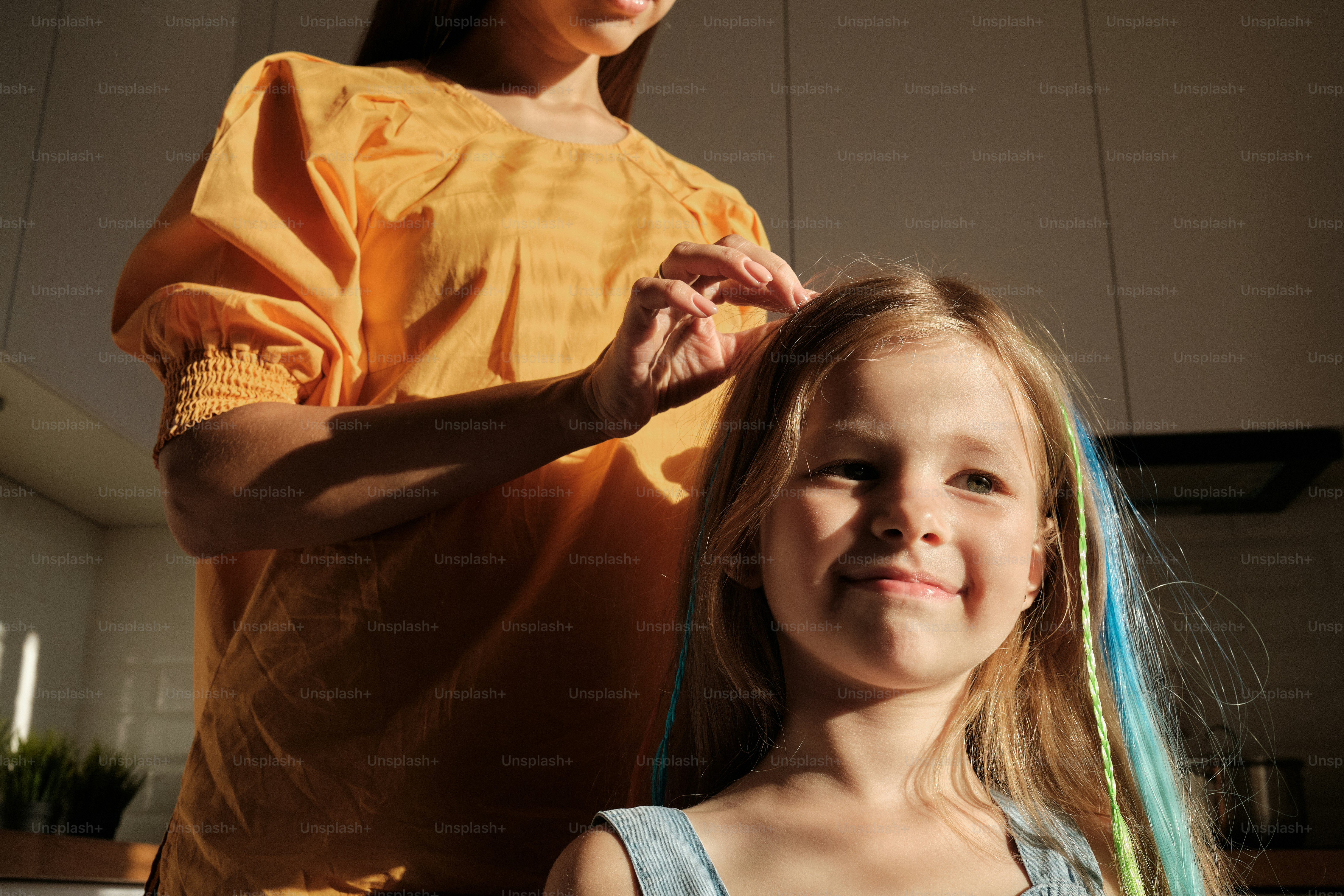 A little girl getting her hair cut by a woman photo – Relationship ...