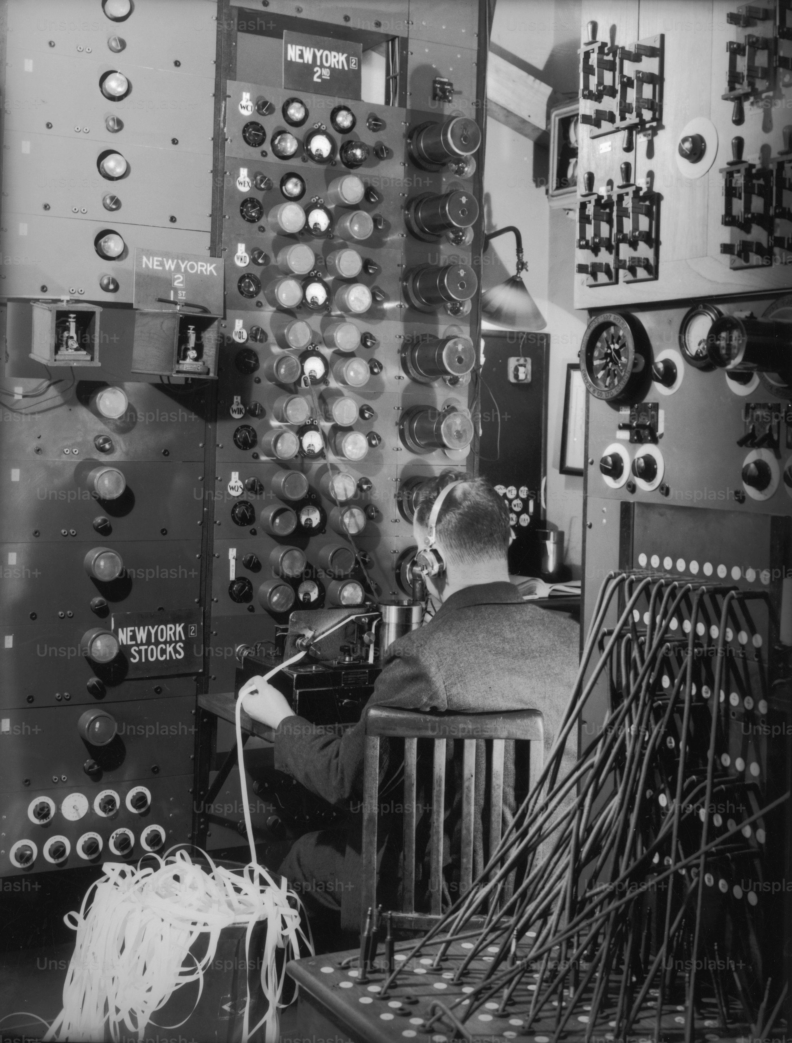 Circa 1938: A telegraph operator receiving a ticker tape message at a ...