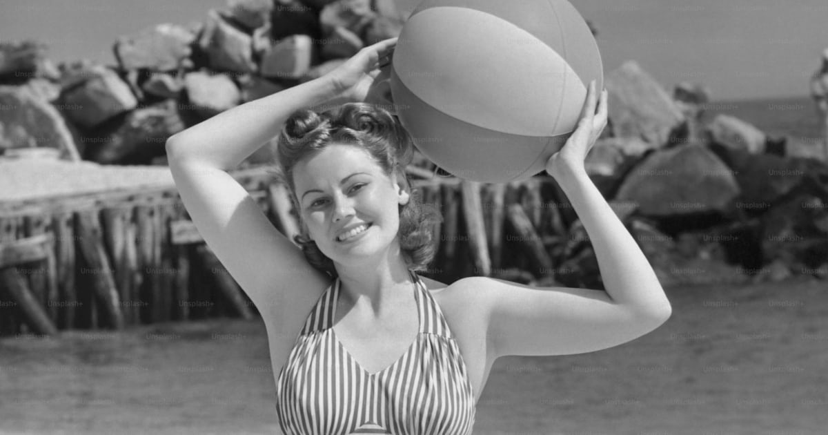 미국 1950년대경 비치볼을 들고 해변에 있는 여성 사진 Unsplash의 흑백 이미지