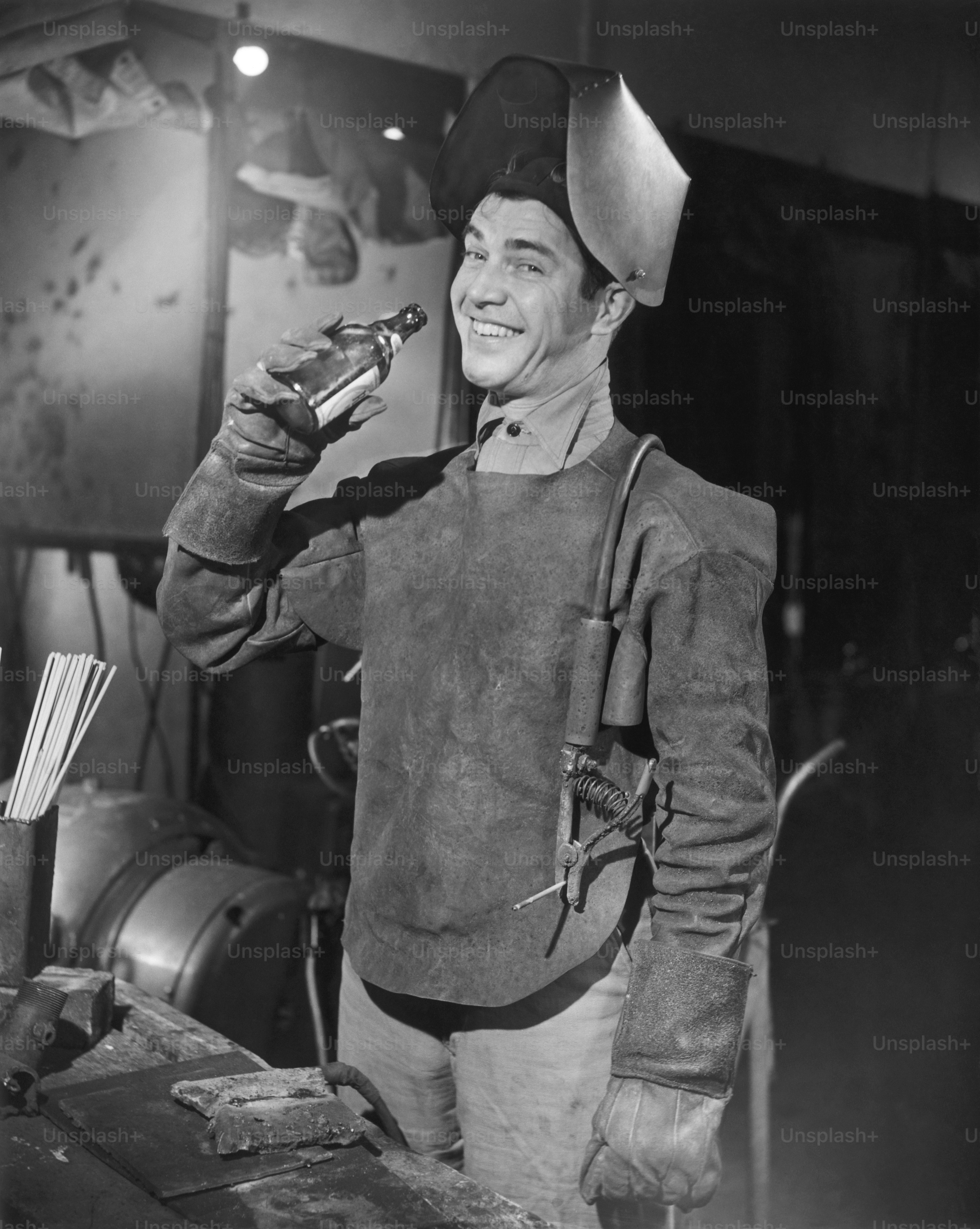 UNITED STATES - CIRCA 1950s: Welder enjoying beer break at foundry ...