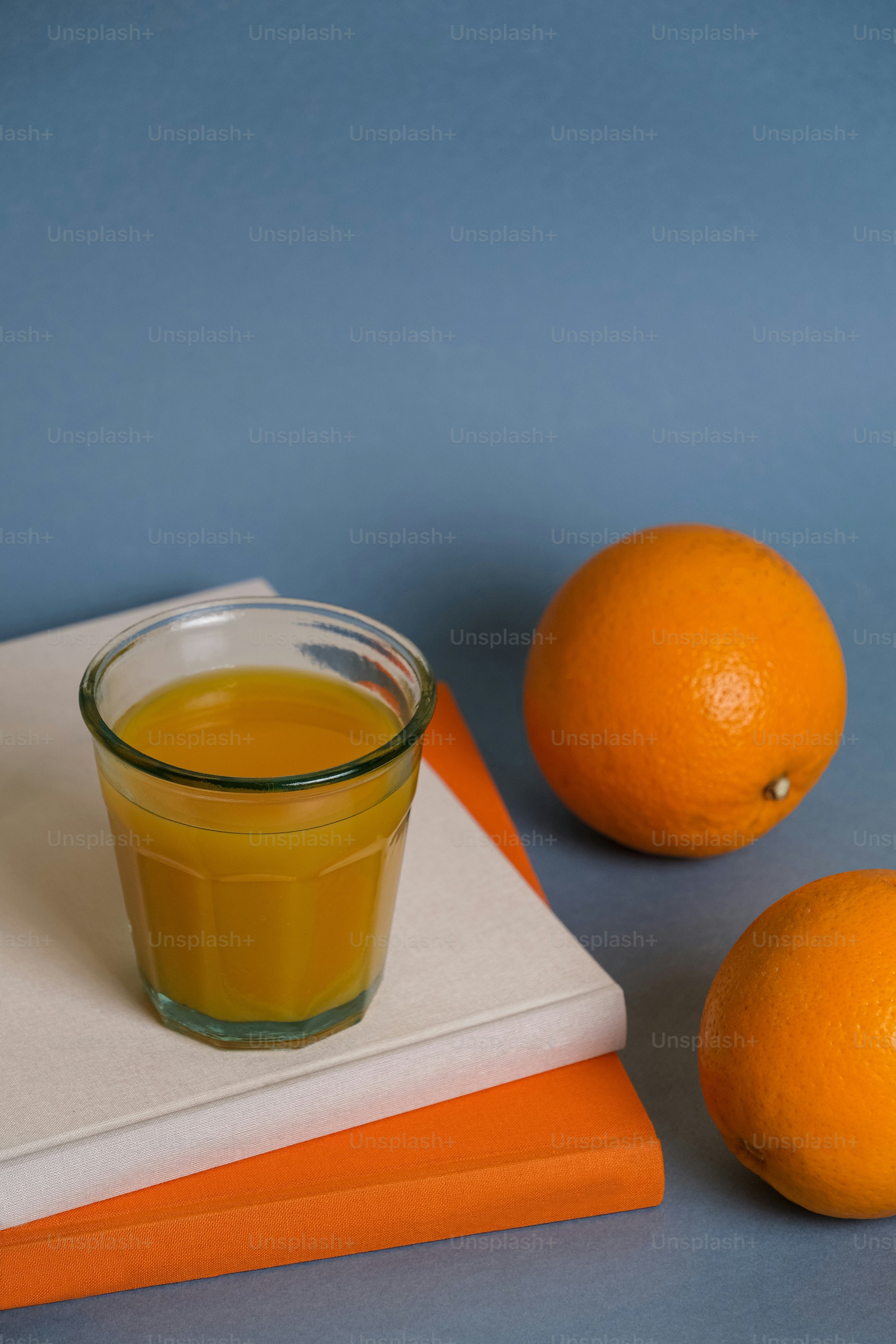 Un verre de jus d’orange à côté de deux oranges photo – Image de Livres ...