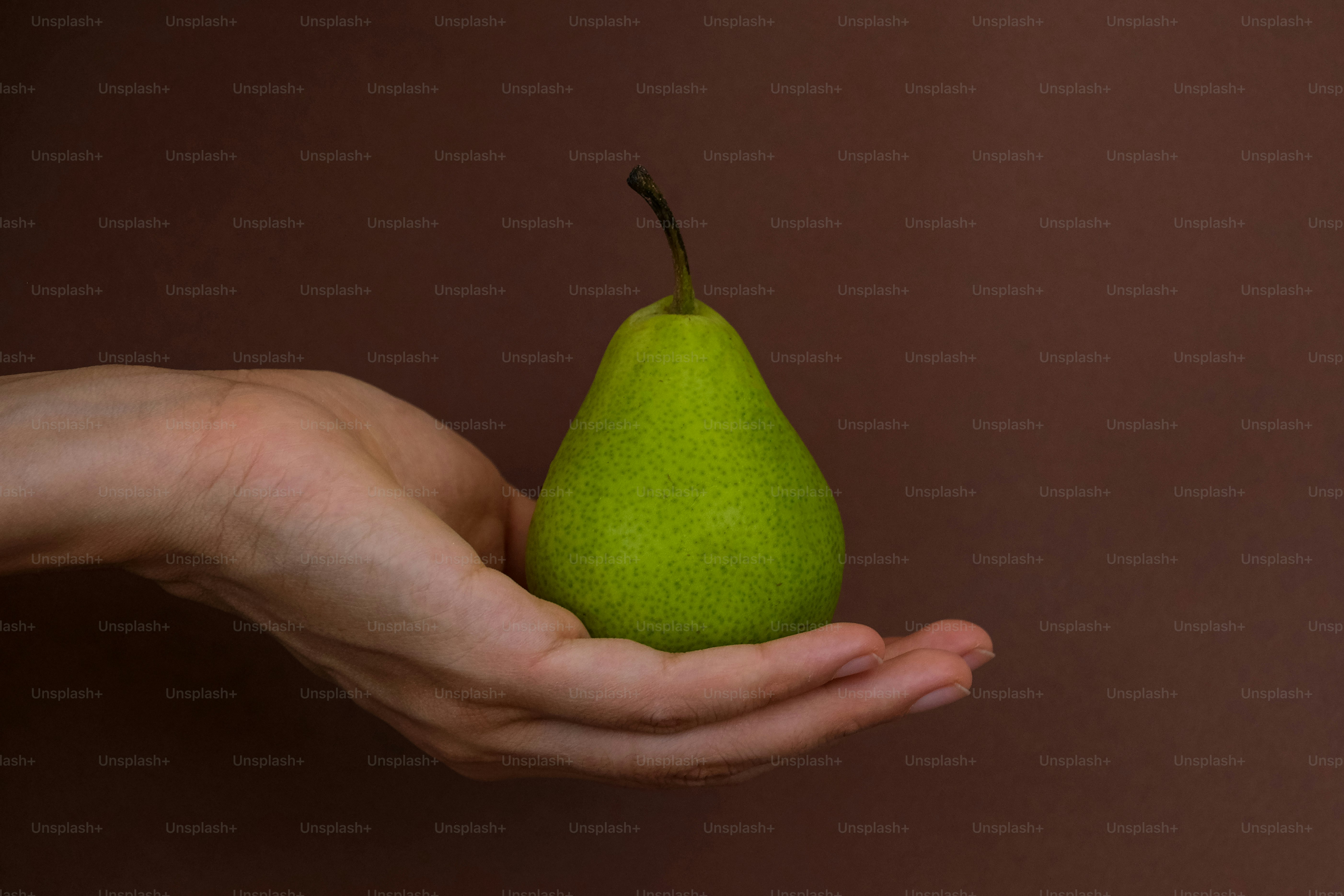A person holding a green pear in their hand photo – Fruit Image on Unsplash