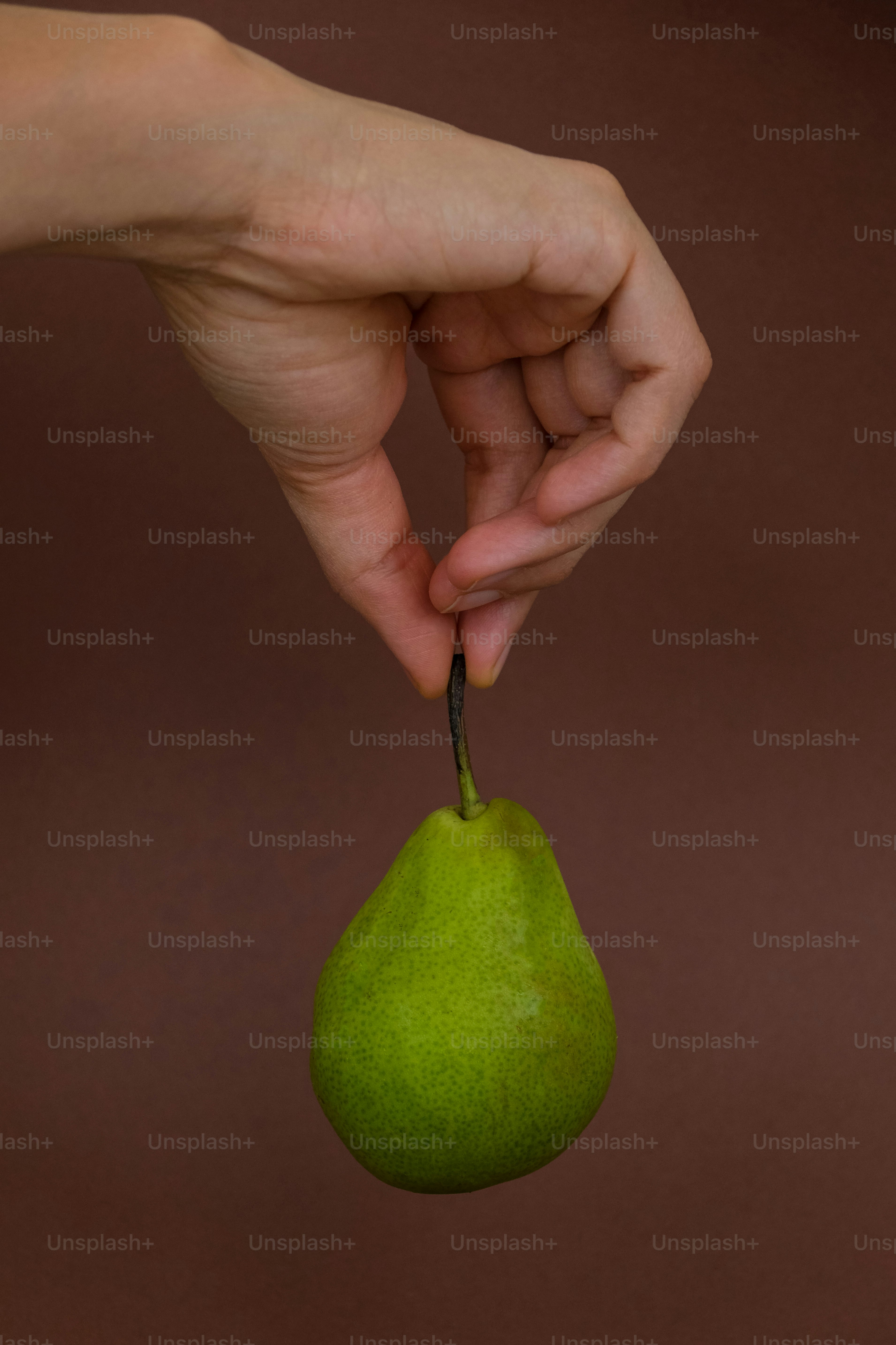 A person holding a green pear in their hand photo – Pear Image on Unsplash