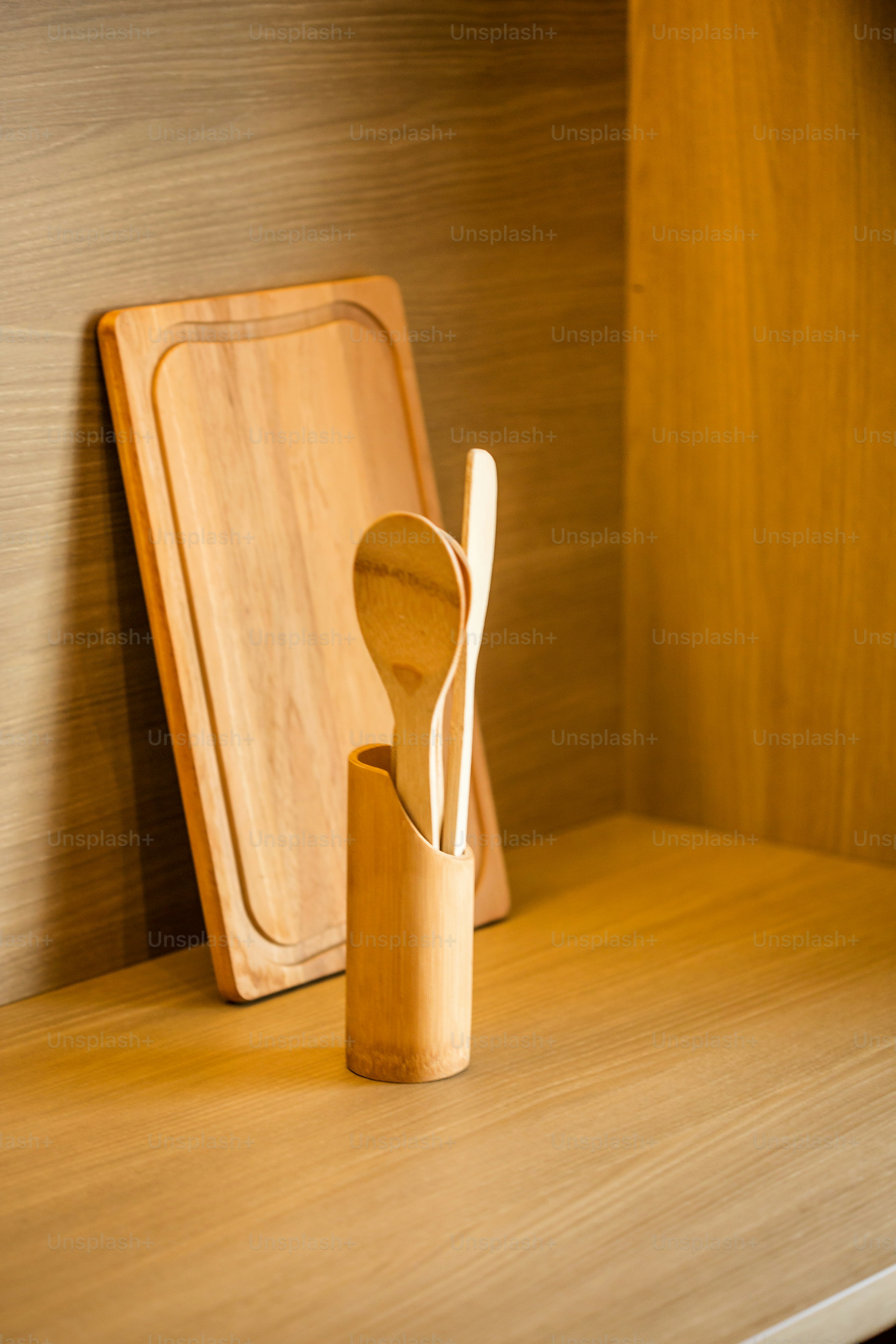 A wooden spoon and a wooden spoon holder on a shelf photo – Kitchen ...