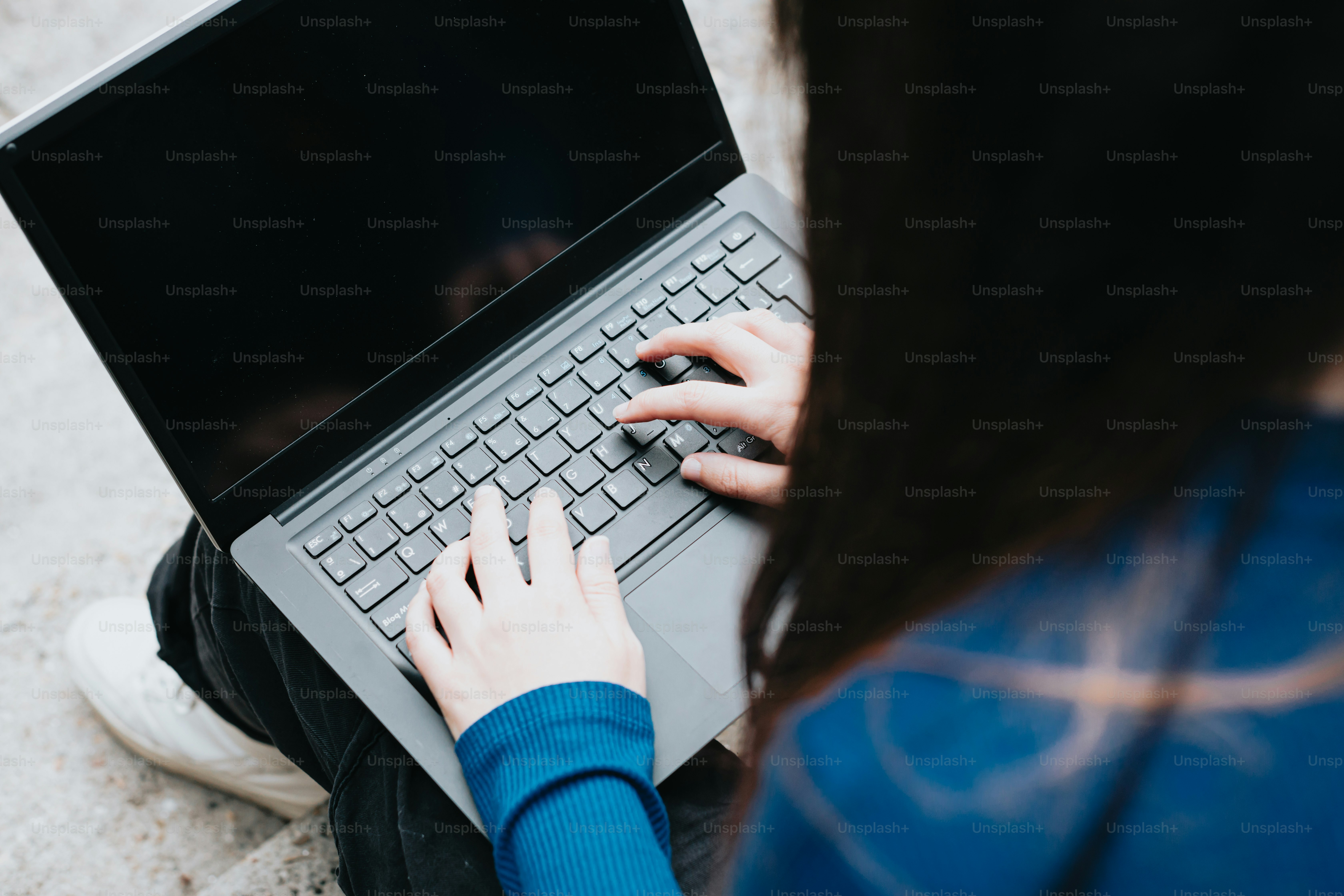 A woman sitting on the ground typing on a laptop photo – Working Image ...