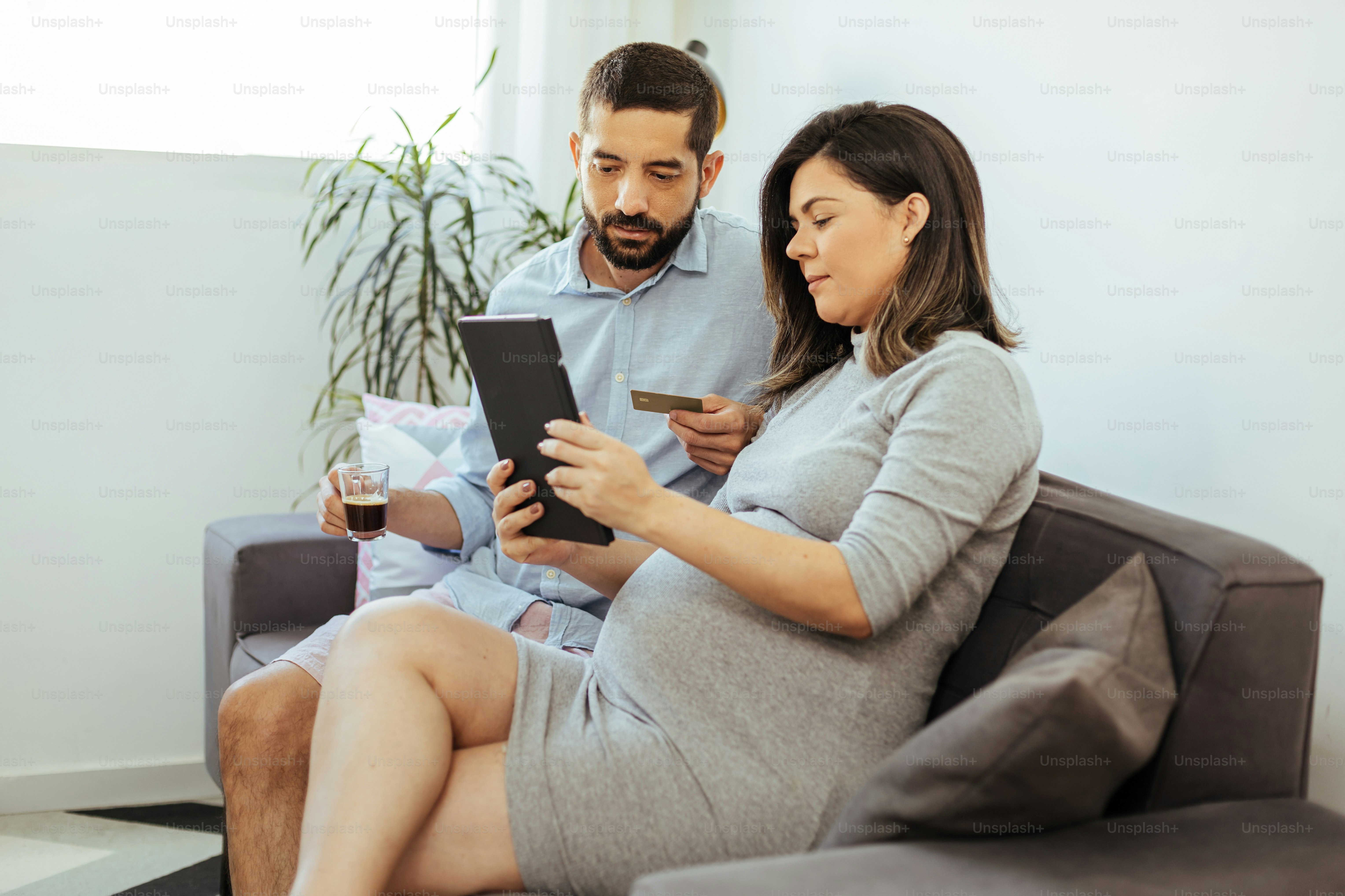 Adult couple expecting baby shopping online at home. photo – Credit ...