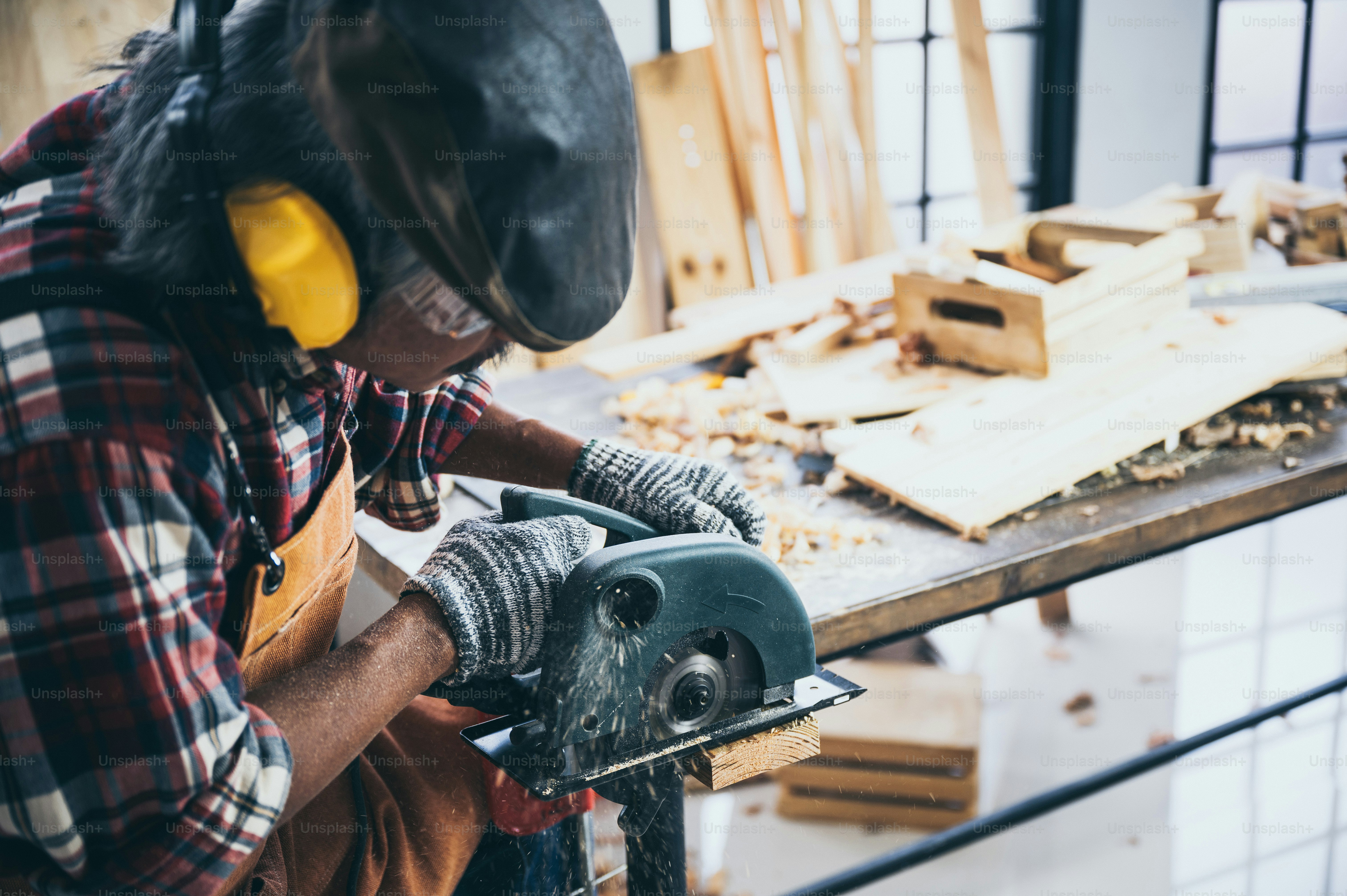Carpenter working on woodworking machines in carpentry shop. woman ...