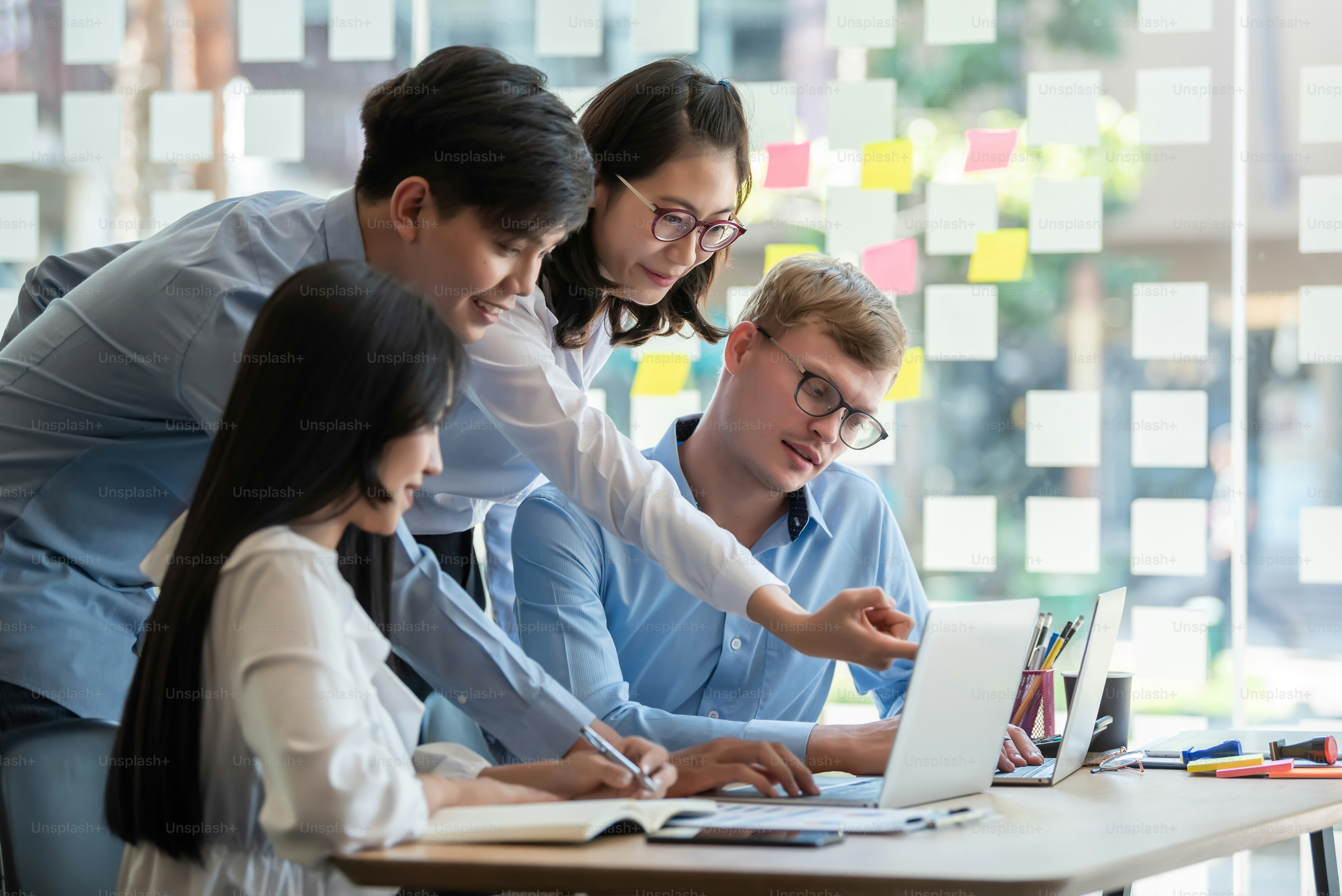 Foto zum Thema Teamwork von jungen asiatischen Geschäftsleuten, die ...