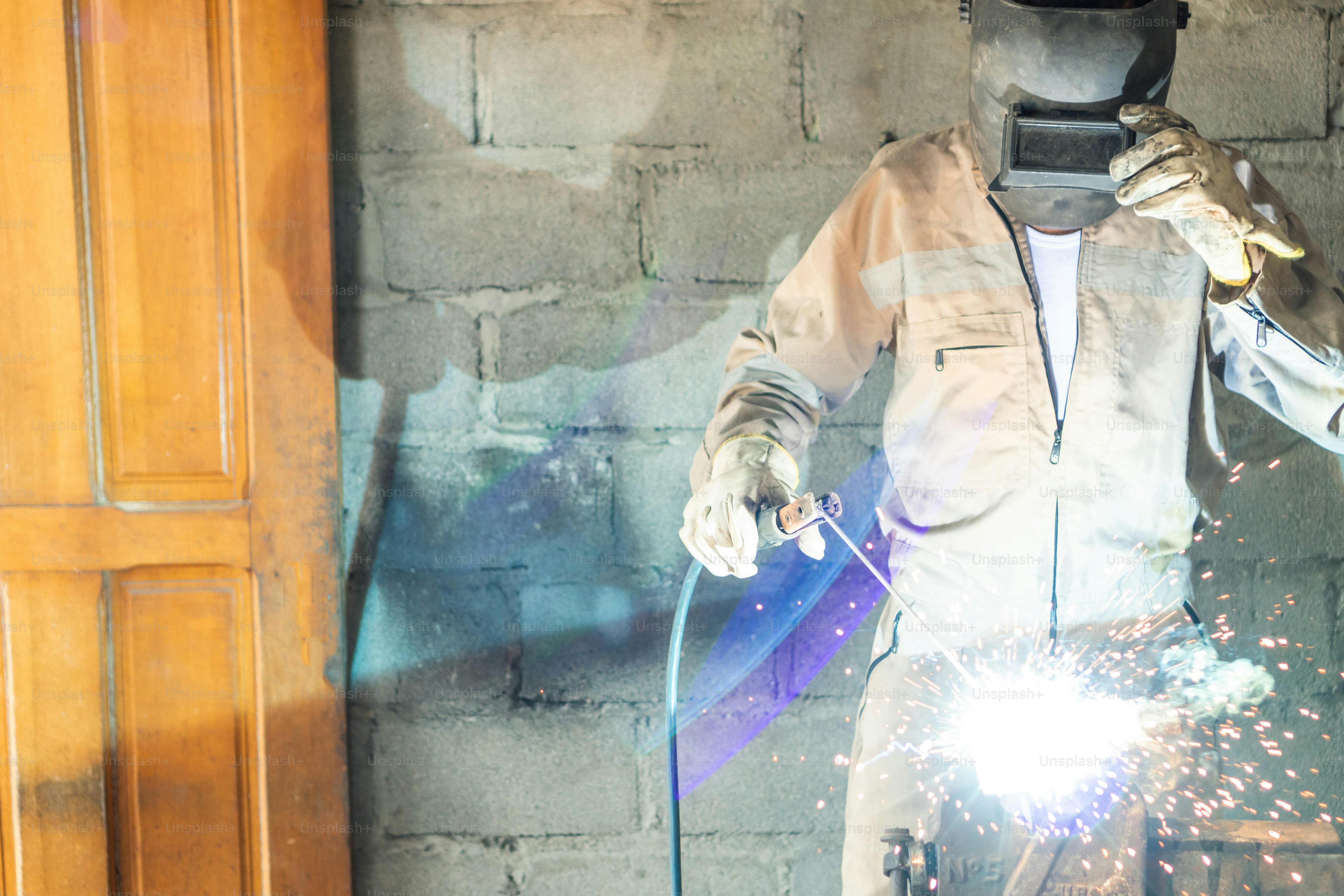 Foto Soldador latino soldando en el patio trasero por la mañana ...