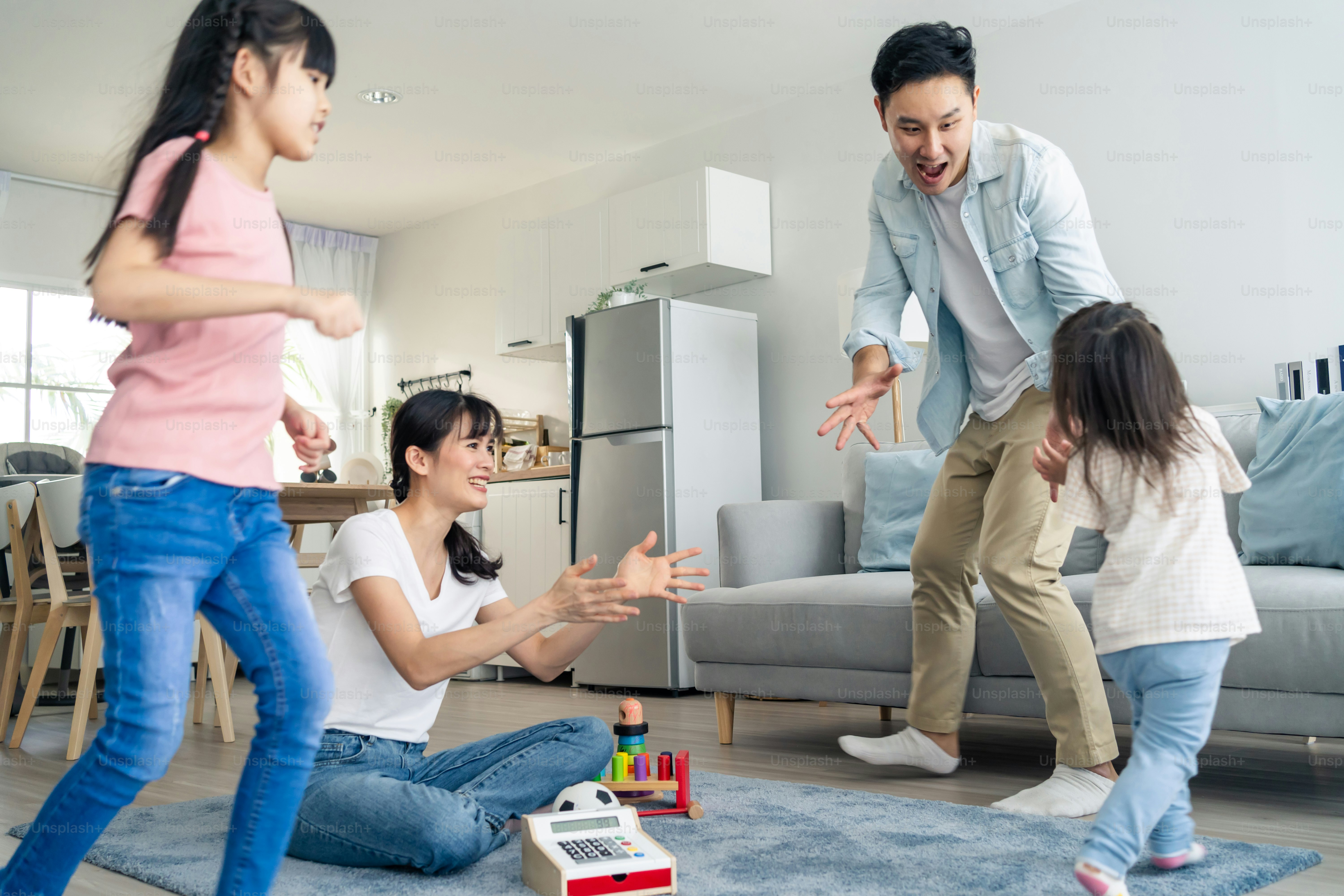 Asian family spending time together on holiday in living room at home ...