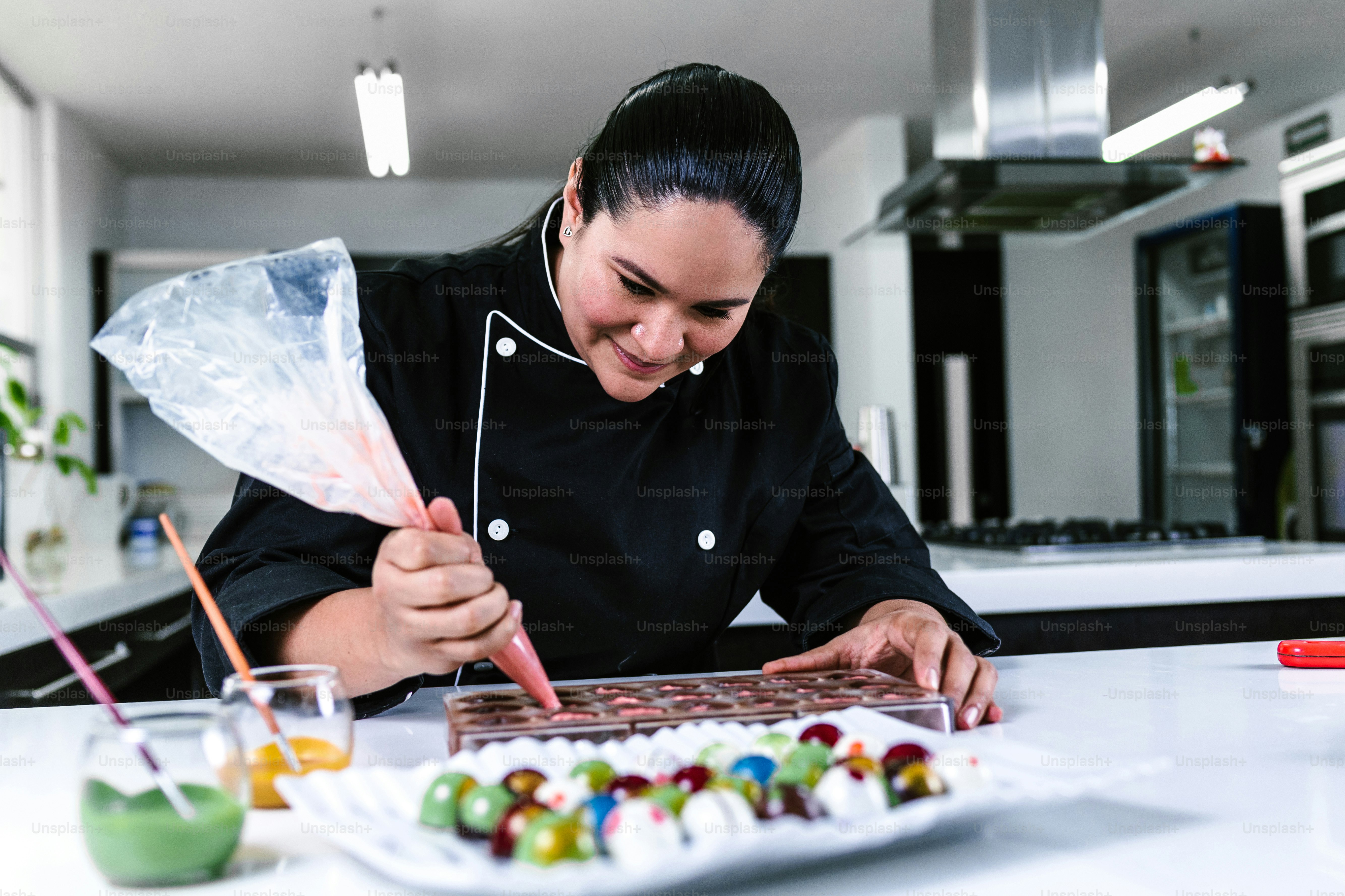 Hand of latin woman pastry chef wearing black uniform in process of ...
