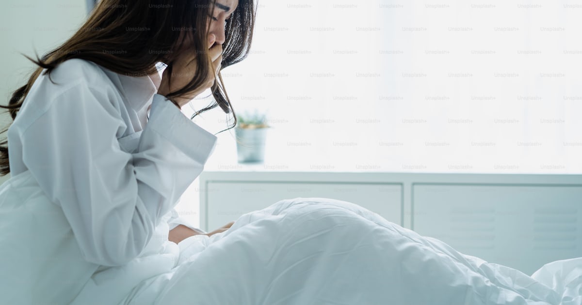 잠옷을 입은 아시아의 아름다운 아픈 소녀가 침실에서 잠에서 깨어납니다 매력적인 젊은 여성은 침대에서 일어나 이른 아침에 집에서