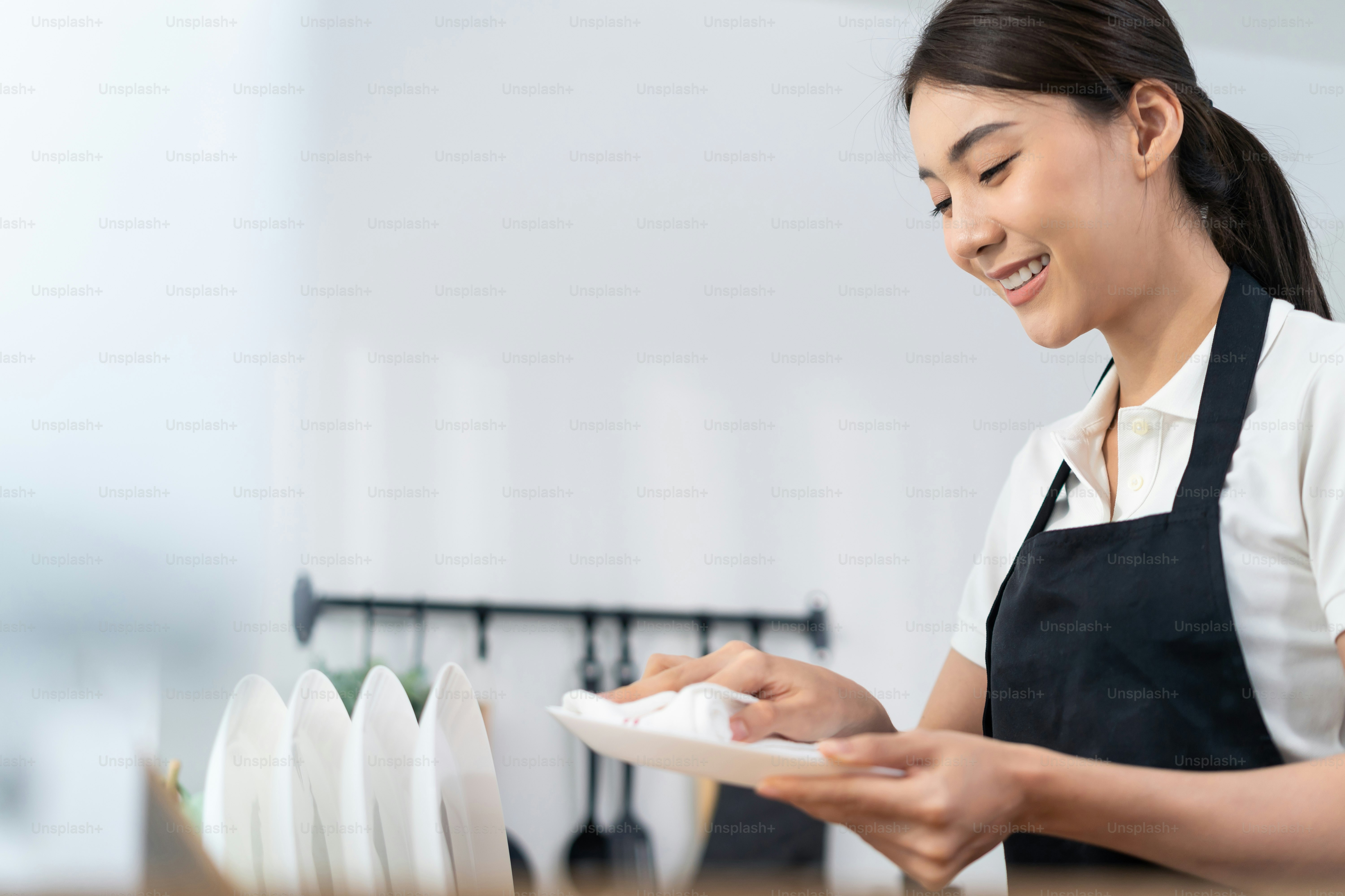 Asian active cleaning service woman worker cleaning in kitchen at home ...