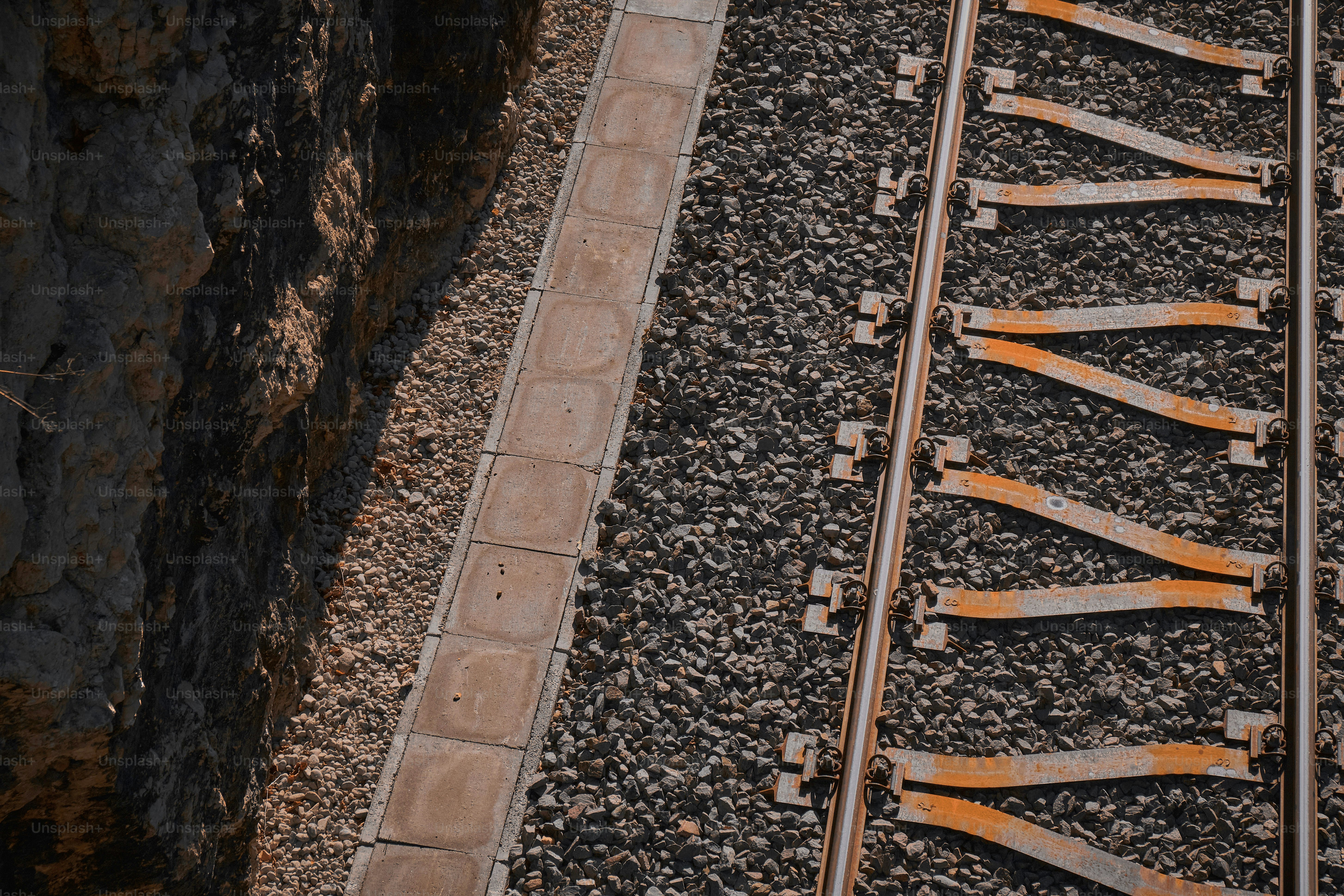 A close up of a train track near a cliff photo – Trains Image on Unsplash