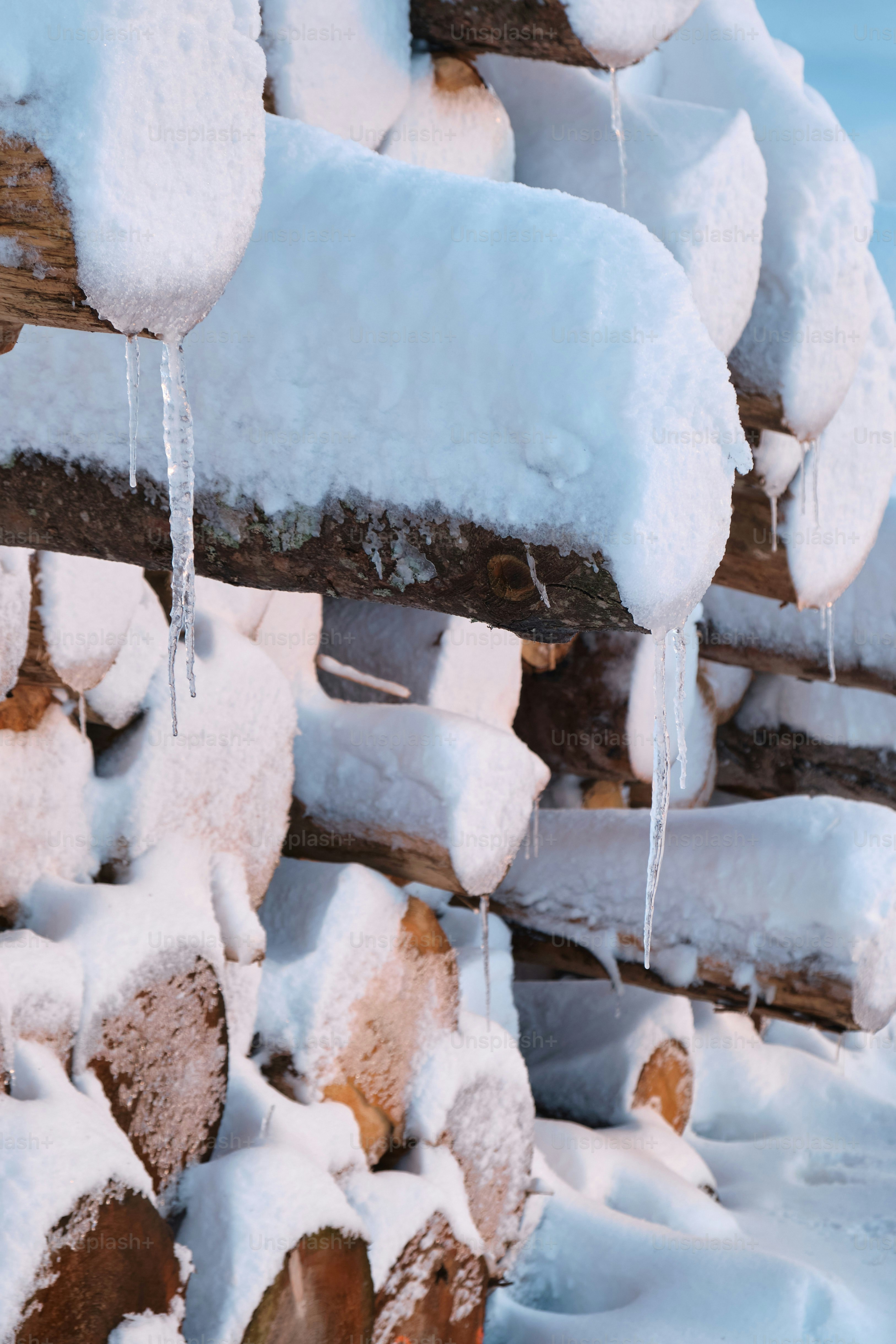 A pile of logs covered in ice and snow photo – Icicles Image on Unsplash