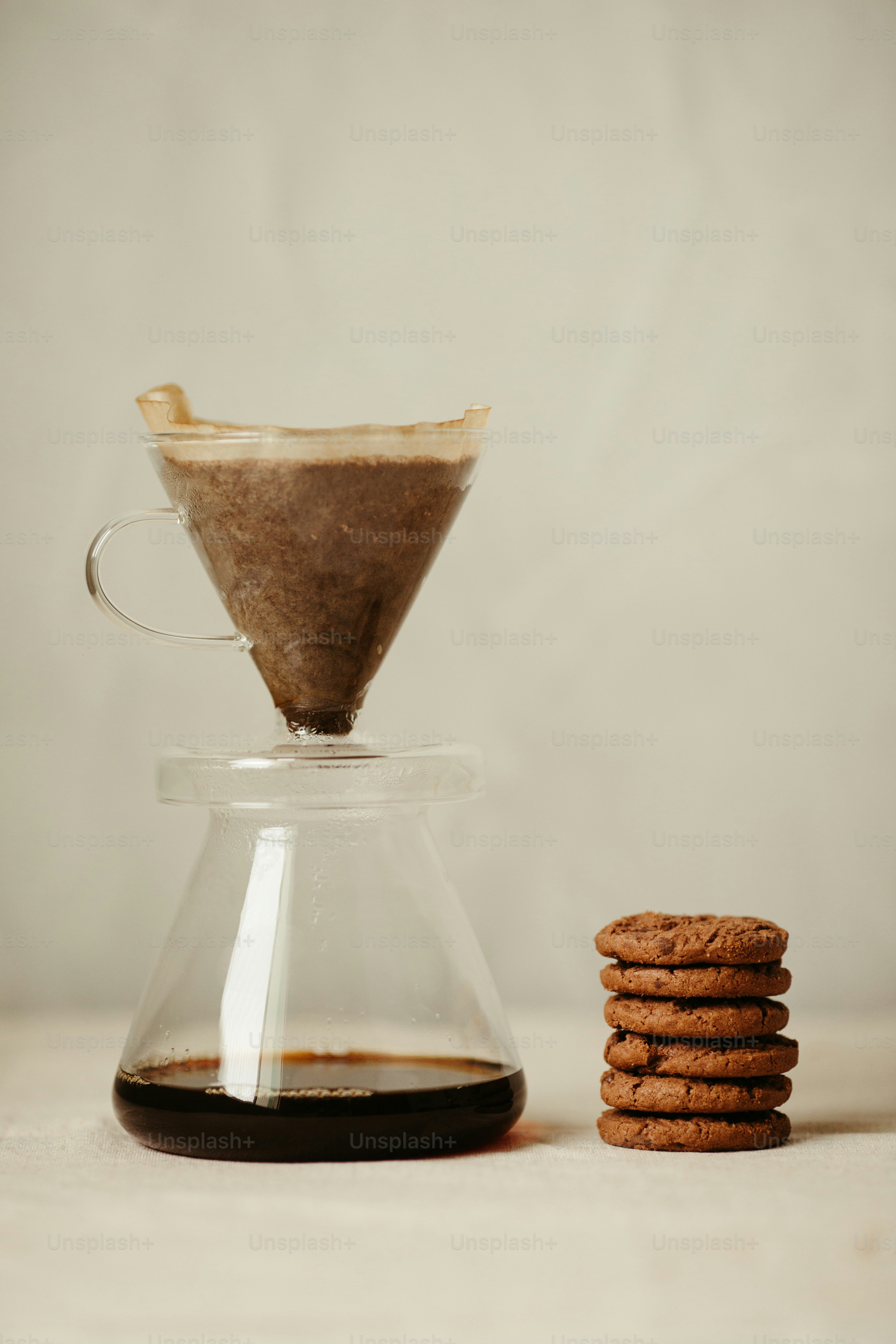 A table topped with a coffee pot next to a cup of coffee photo – Coffee ...