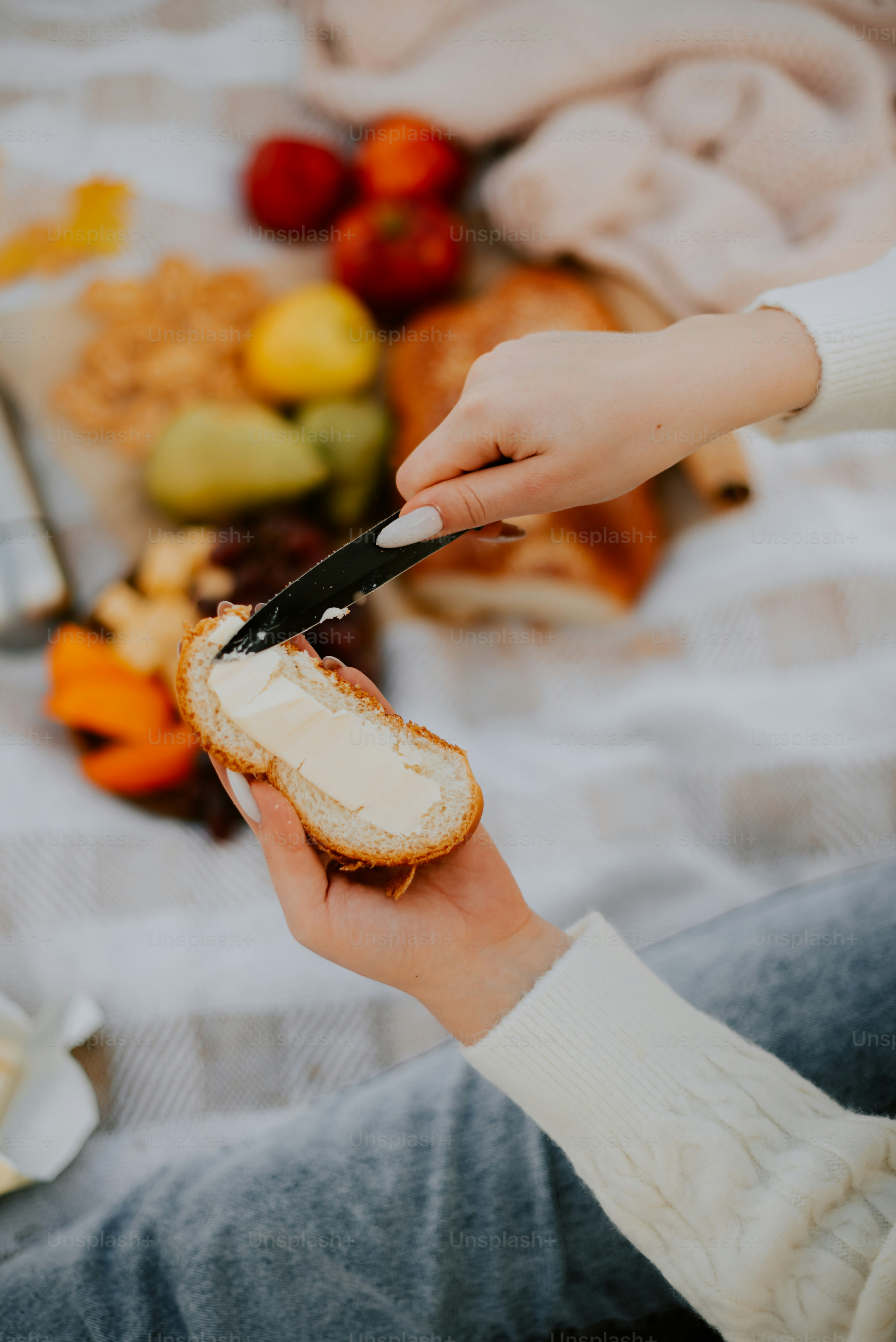 A person cutting a piece of bread with a knife photo – Buttering bread ...
