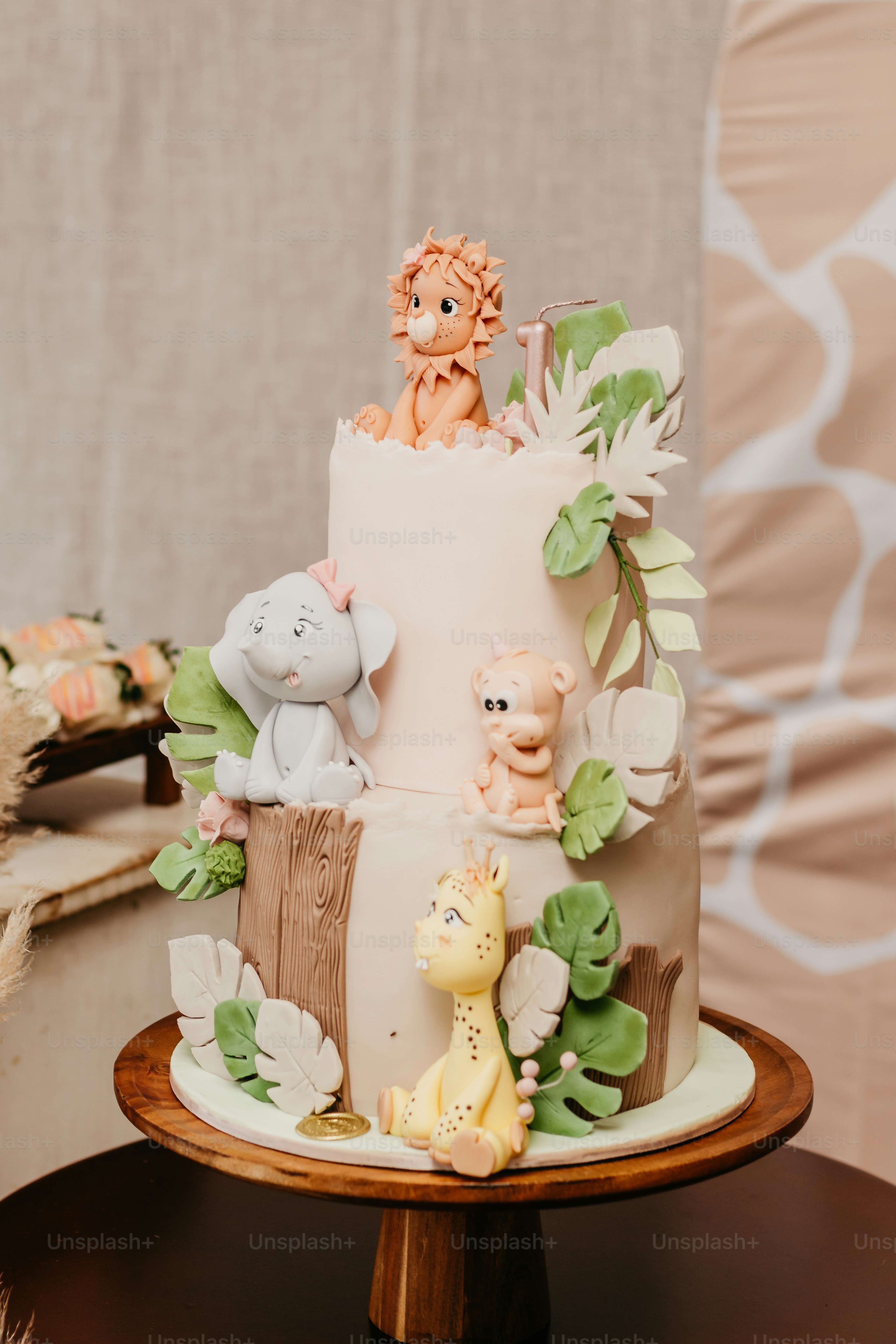 A three tiered cake with animals on top of it photo – Baby birthday ...