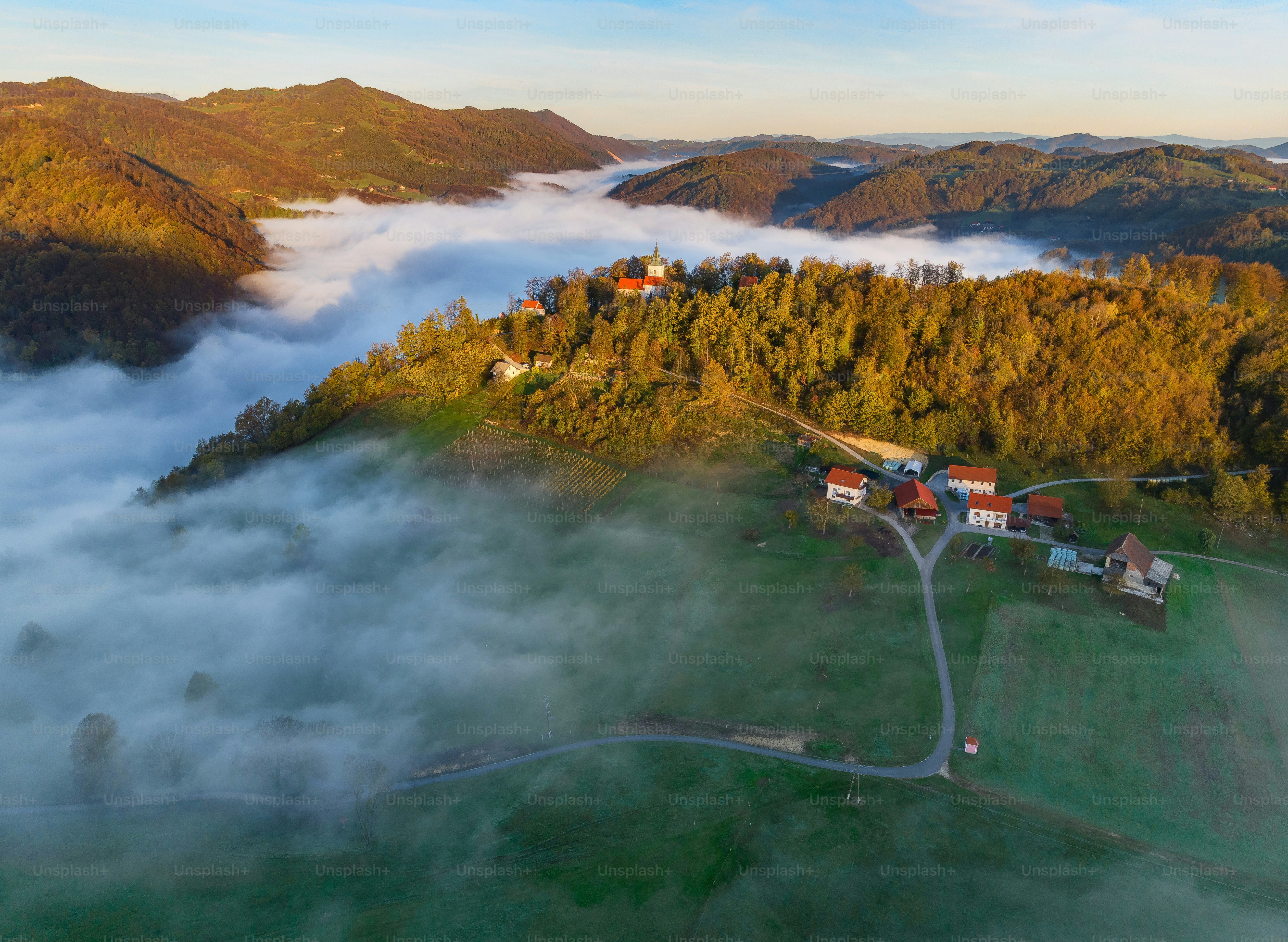 An aerial view of a small village surrounded by fog photo – Foggy Image ...