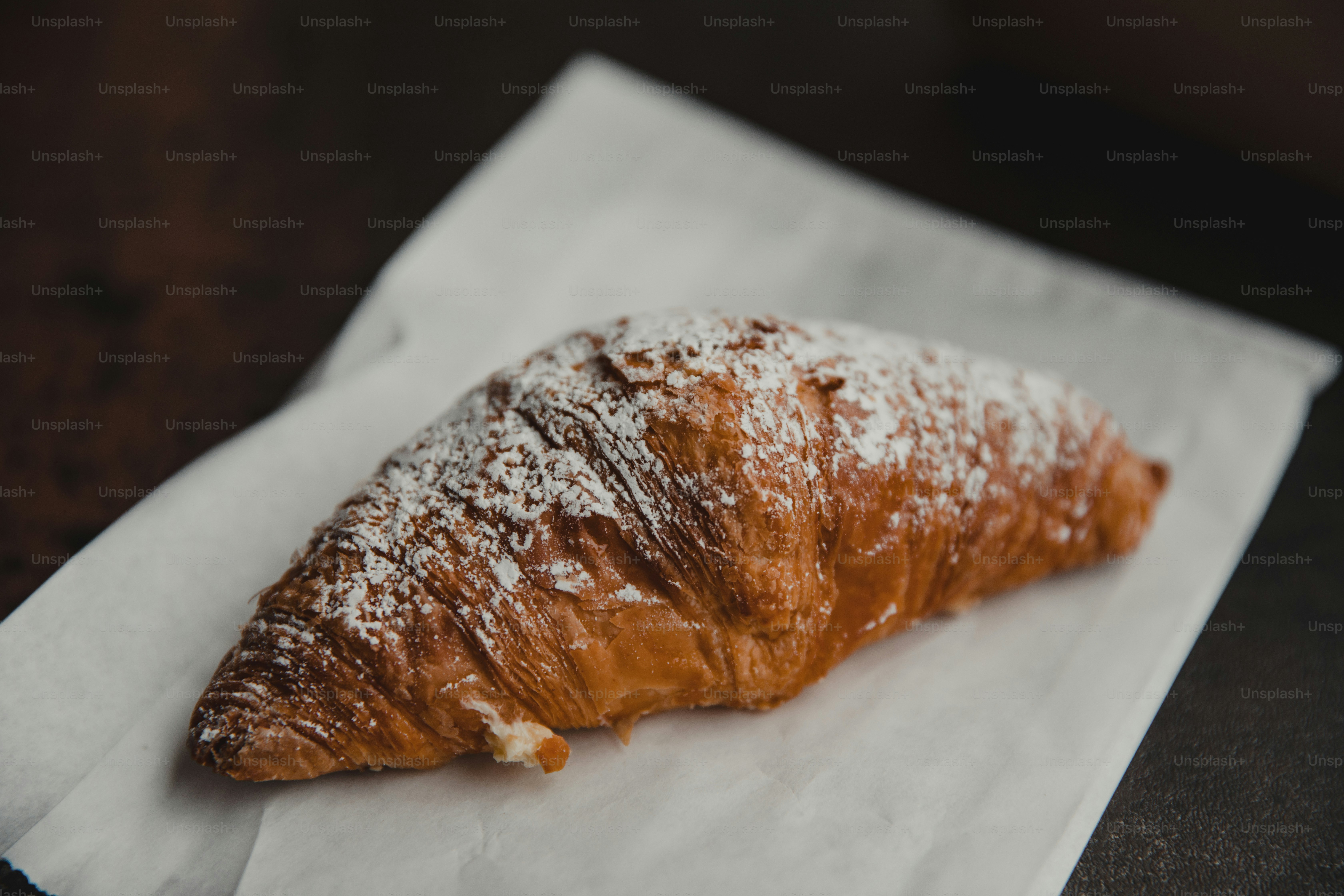 A pastry on a napkin on a table photo – Croissant and coffee Image on ...