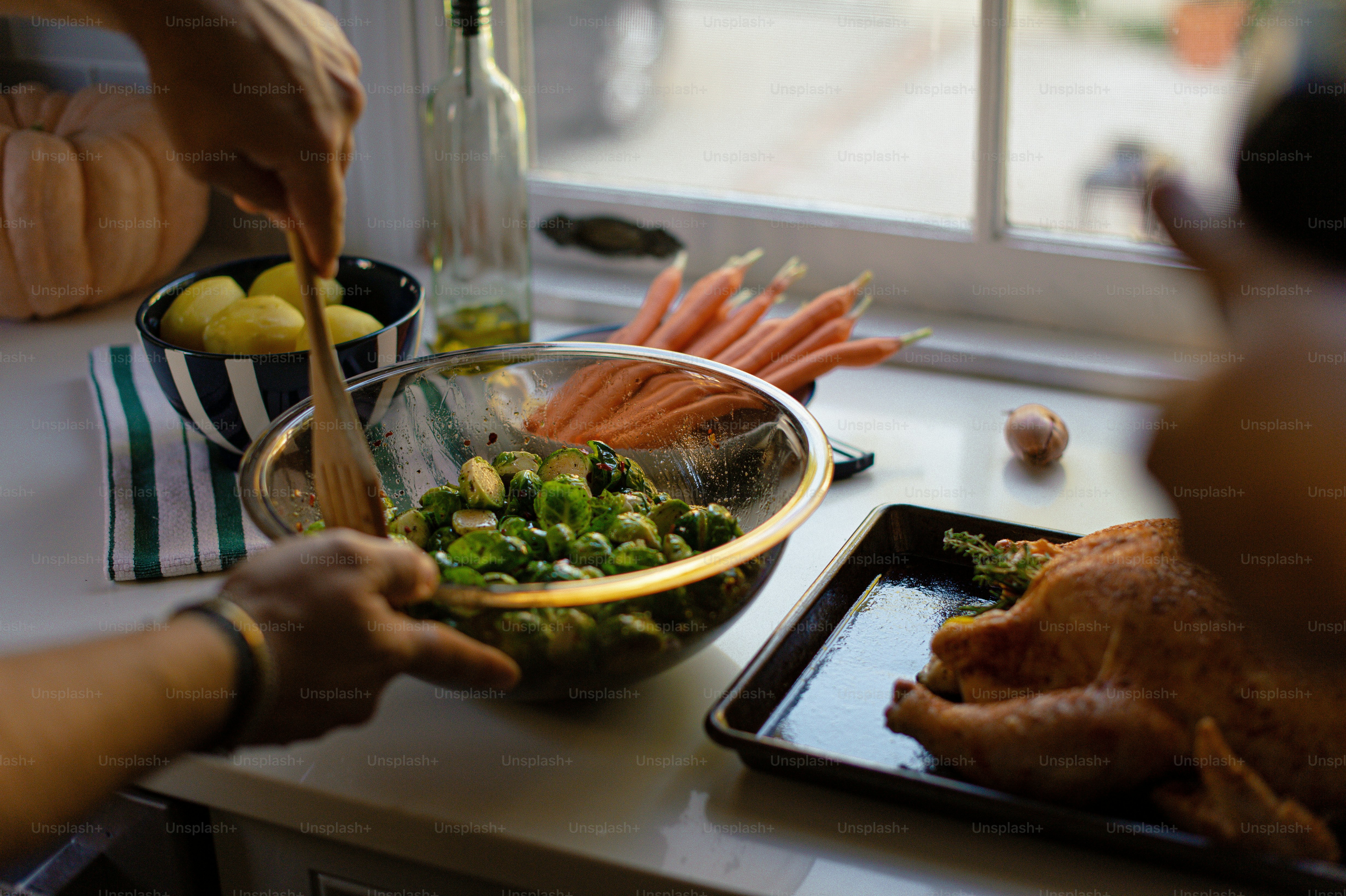 A person preparing food on a counter top photo – Brussel sprouts Image ...