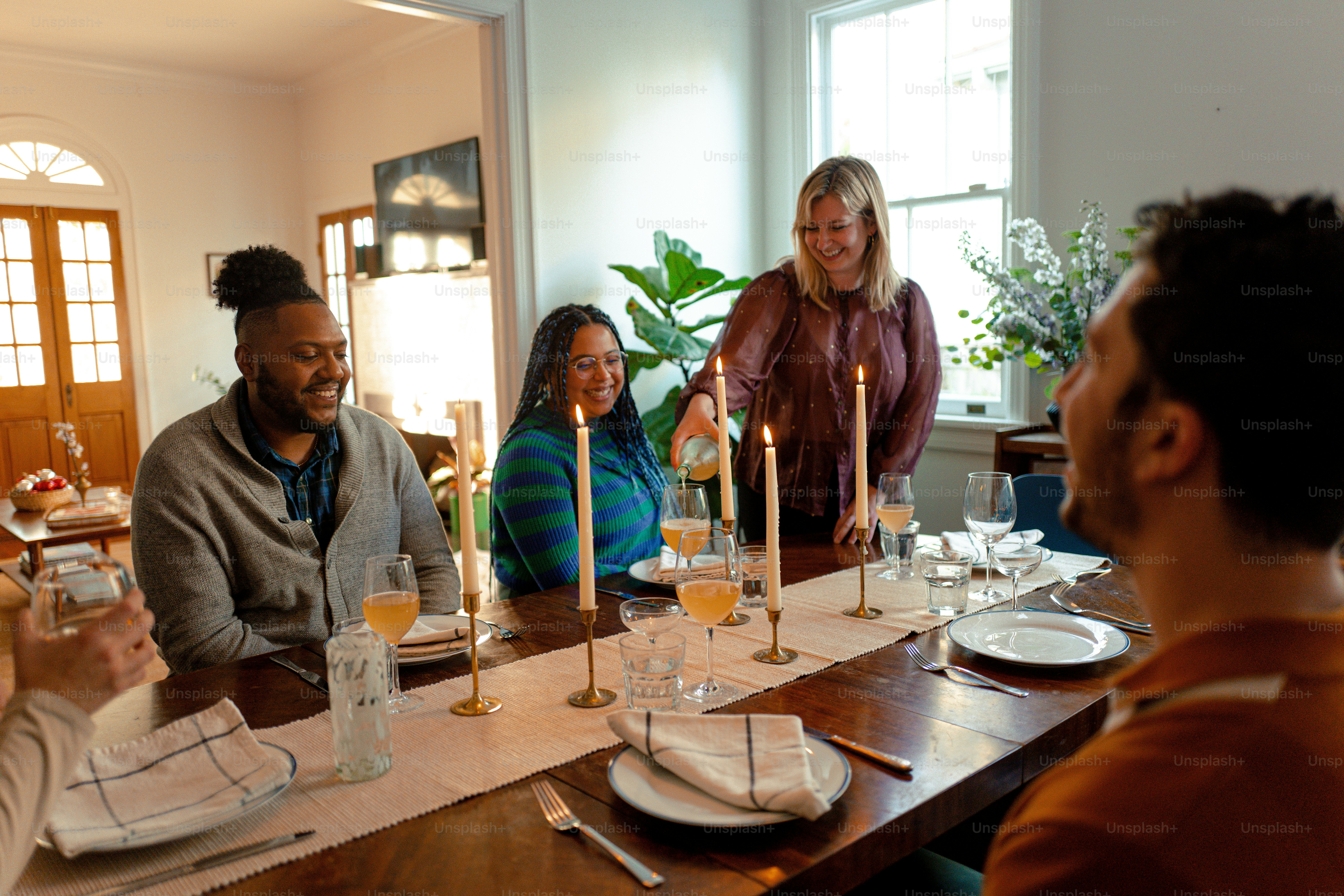A group of people sitting around a dinner table photo – Image on Unsplash