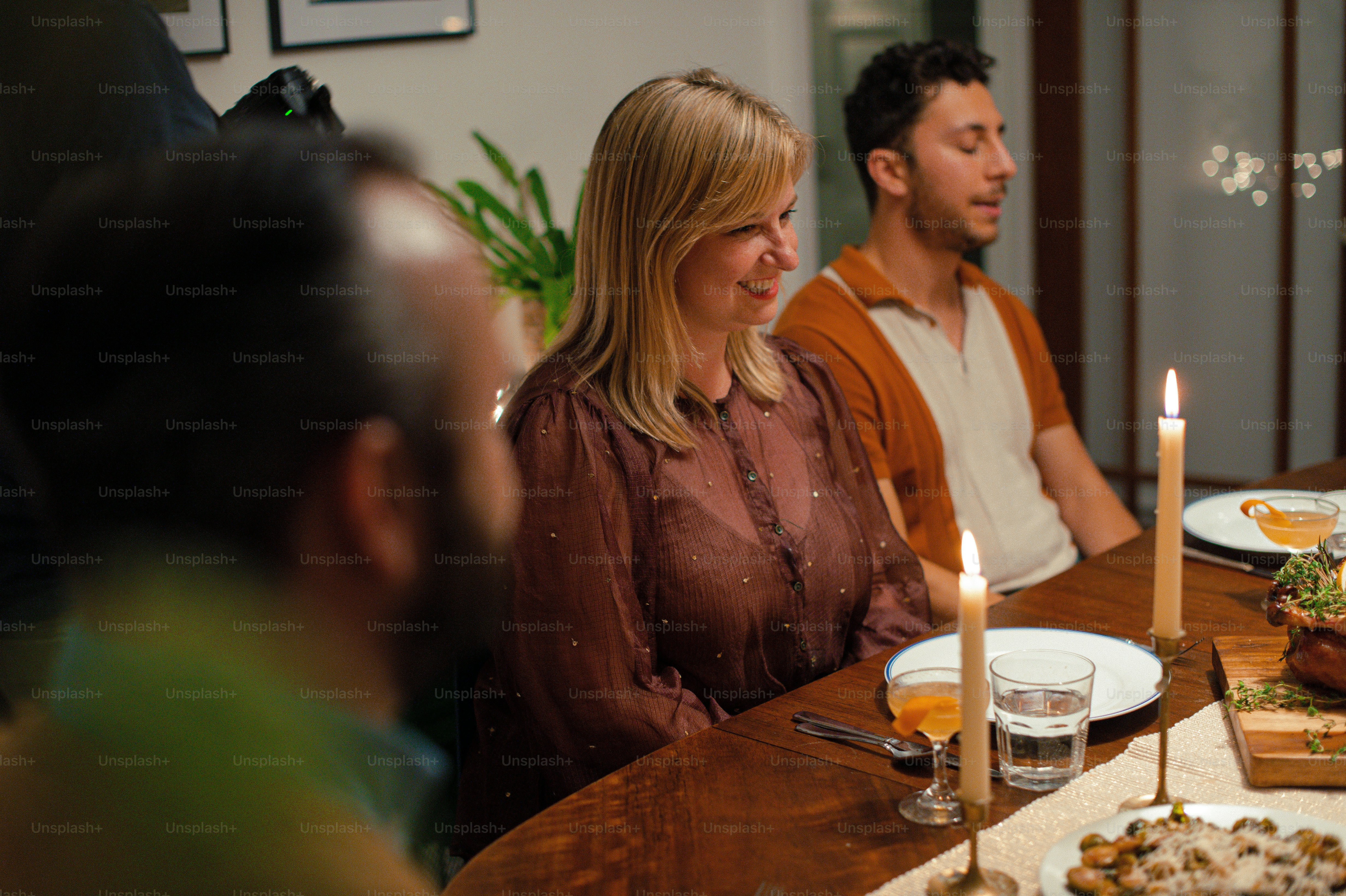 Foto zum Thema Eine Gruppe von Menschen, die mit Essen an einem Tisch ...