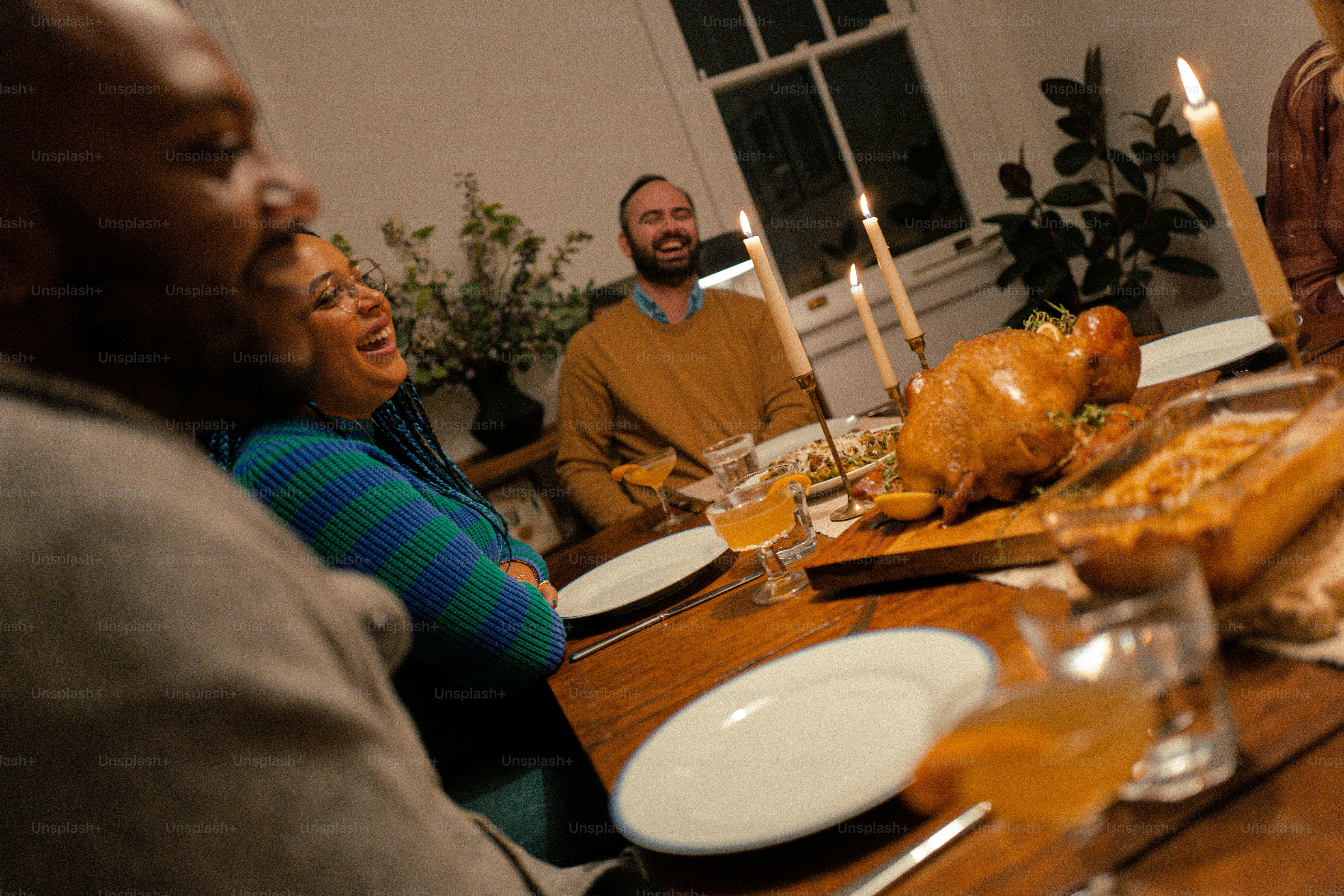 A group of people sitting around a dinner table photo – Food Image on ...