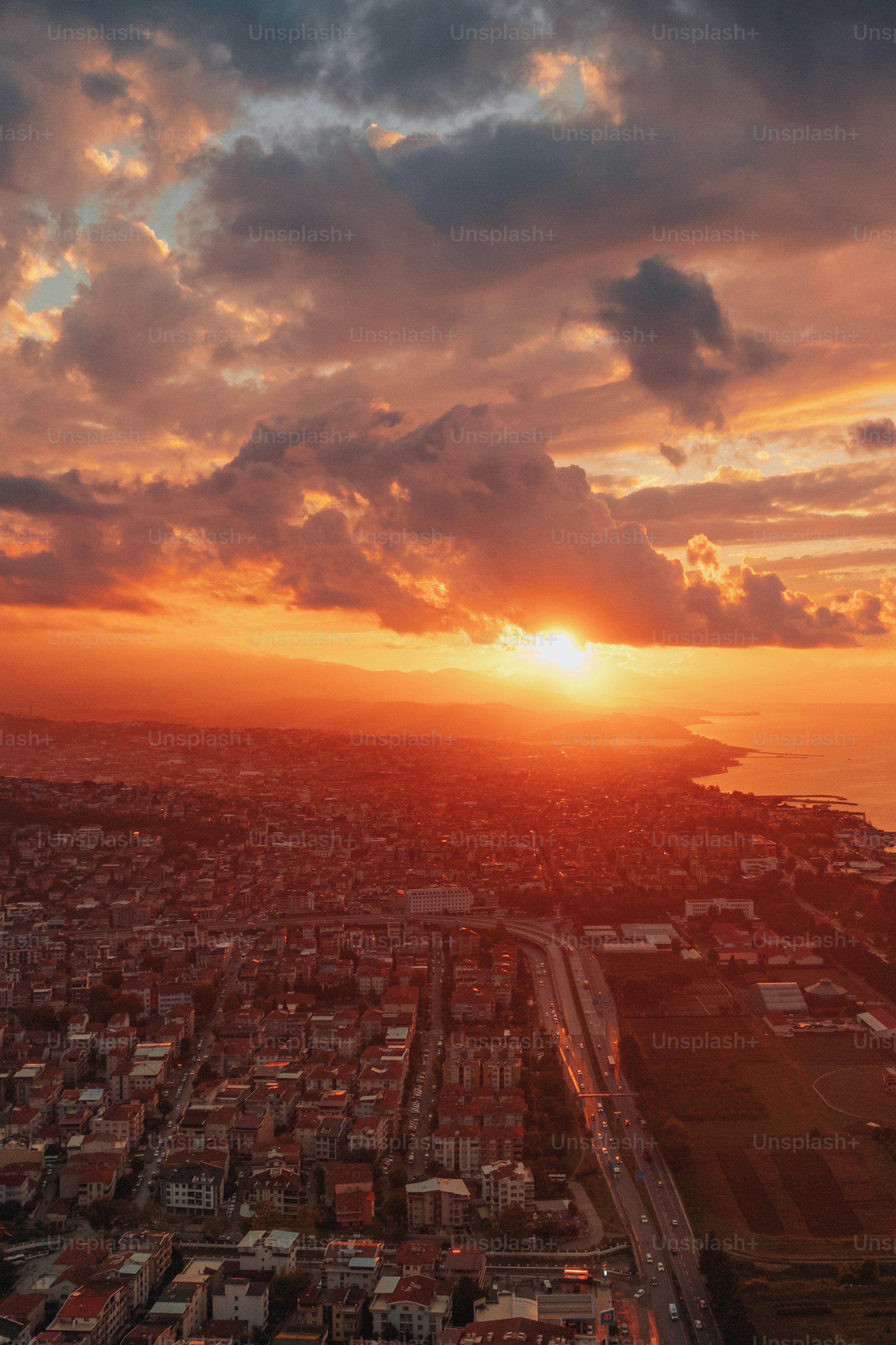 The sun is setting over a large city photo – Wallpapers Image on Unsplash