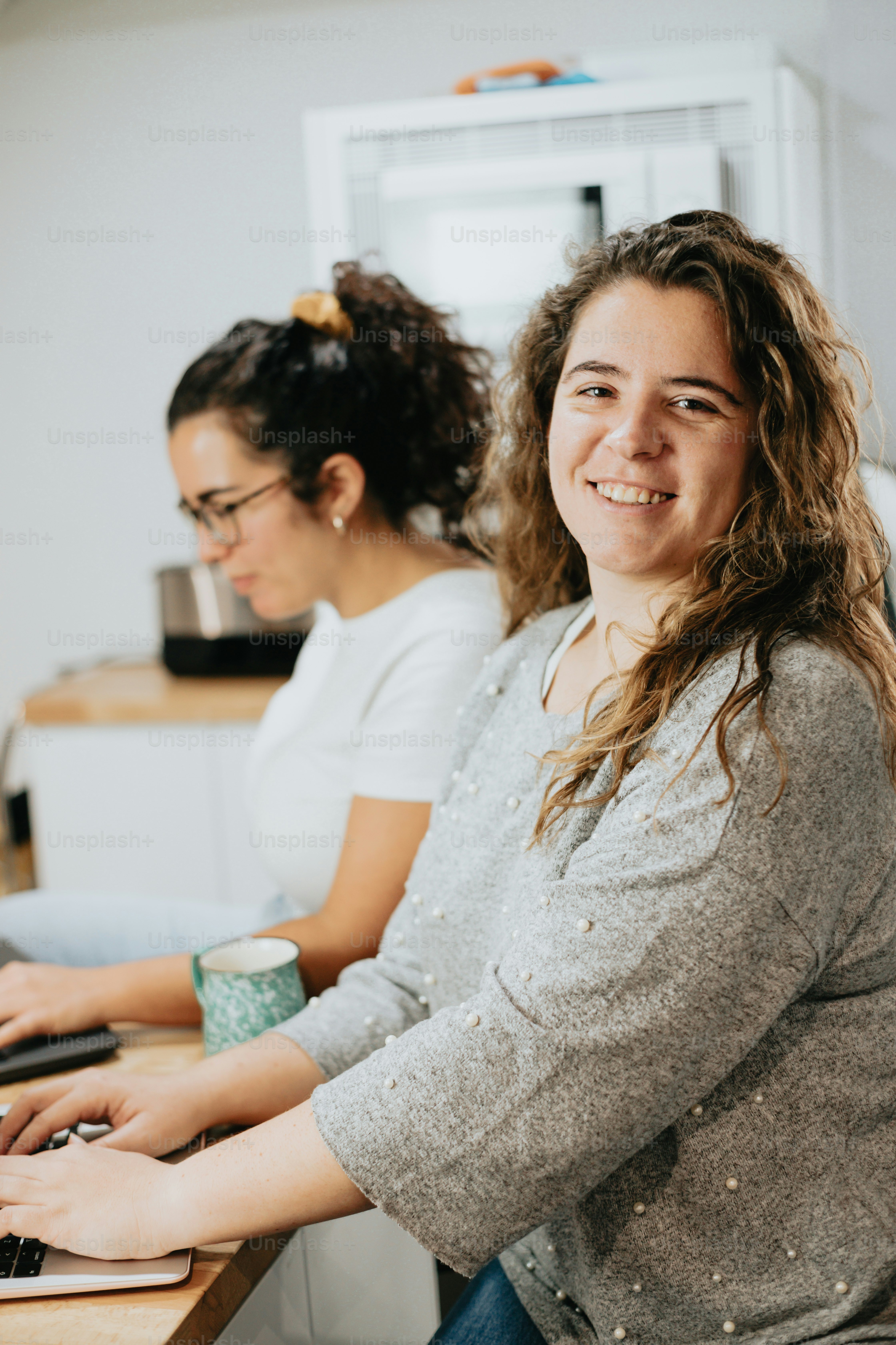 A woman sitting at a desk with a laptop computer photo – Professional ...