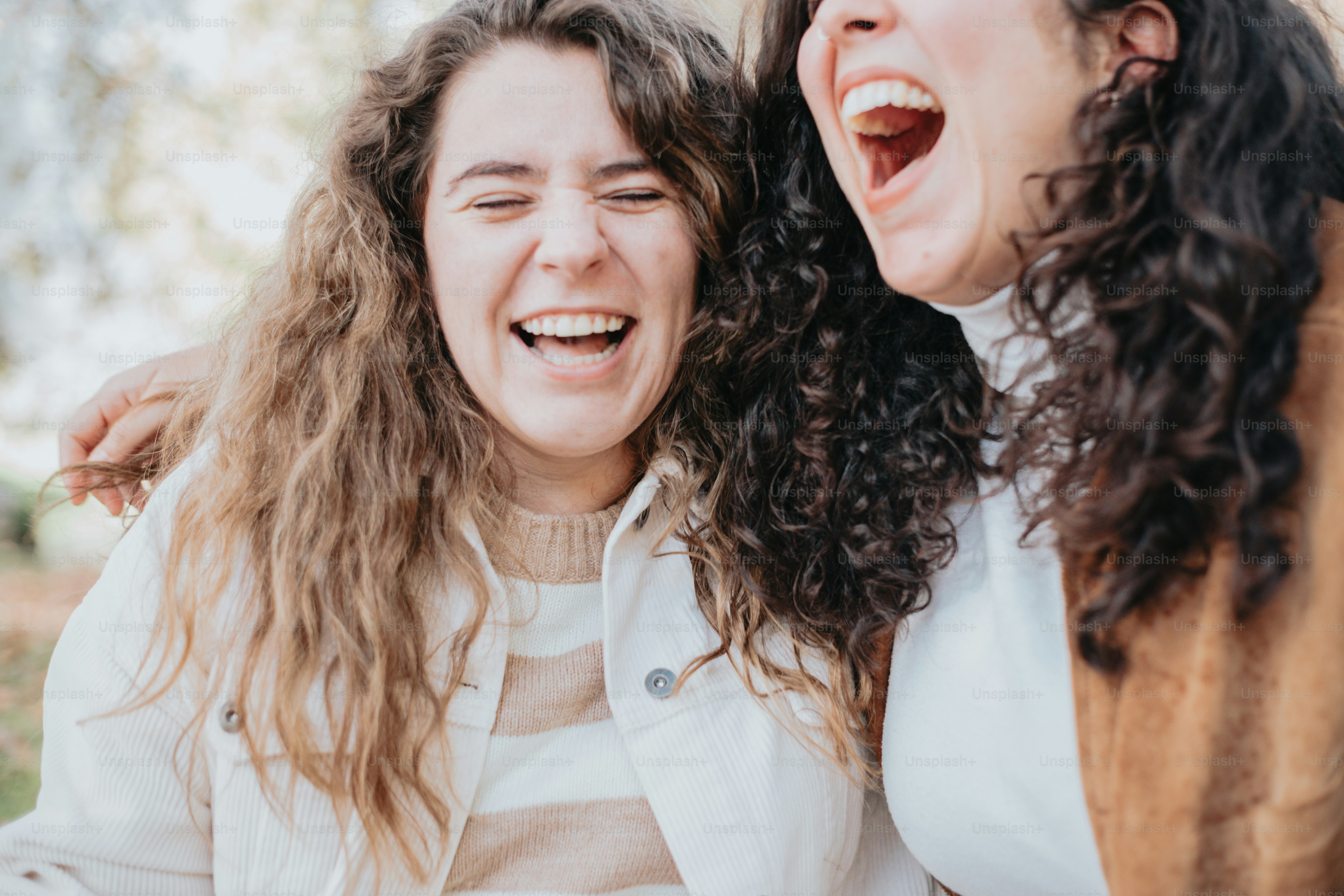 Two women laugh and laugh together in a park photo – People Image on ...
