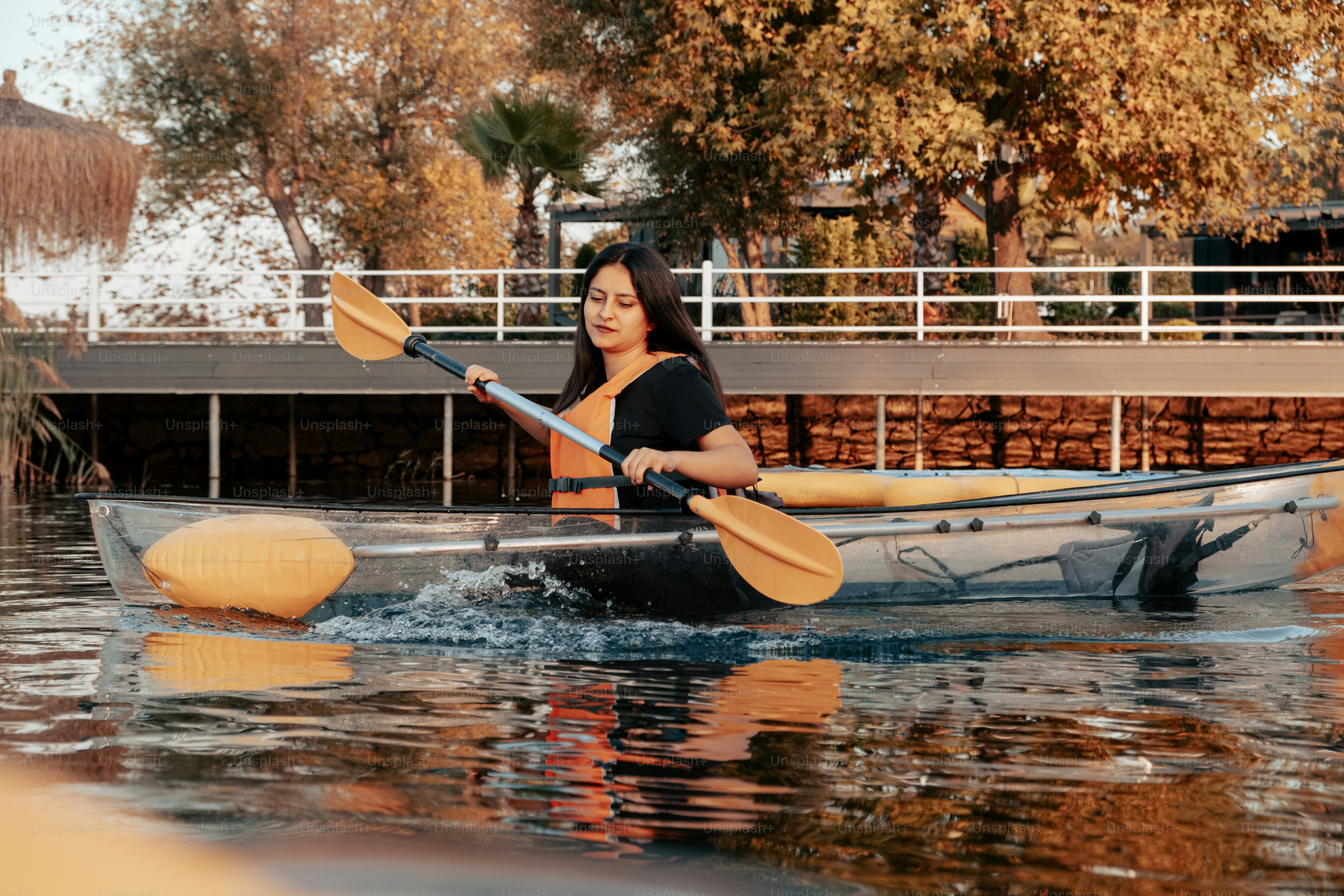 A woman is paddling a canoe in the water photo – Canoe Image on Unsplash
