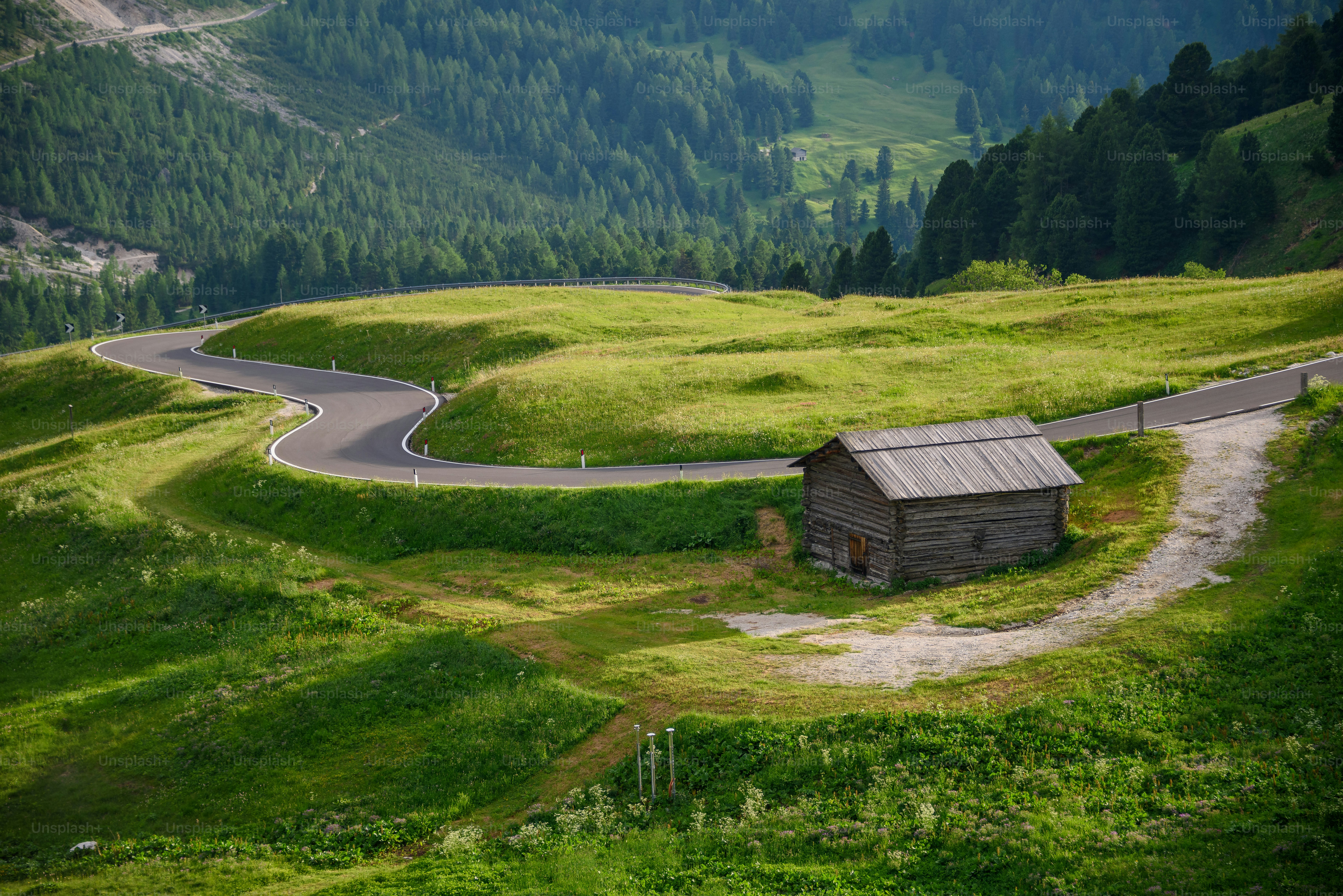 A small house on a winding road in the mountains photo – Shed Image on Unsplash