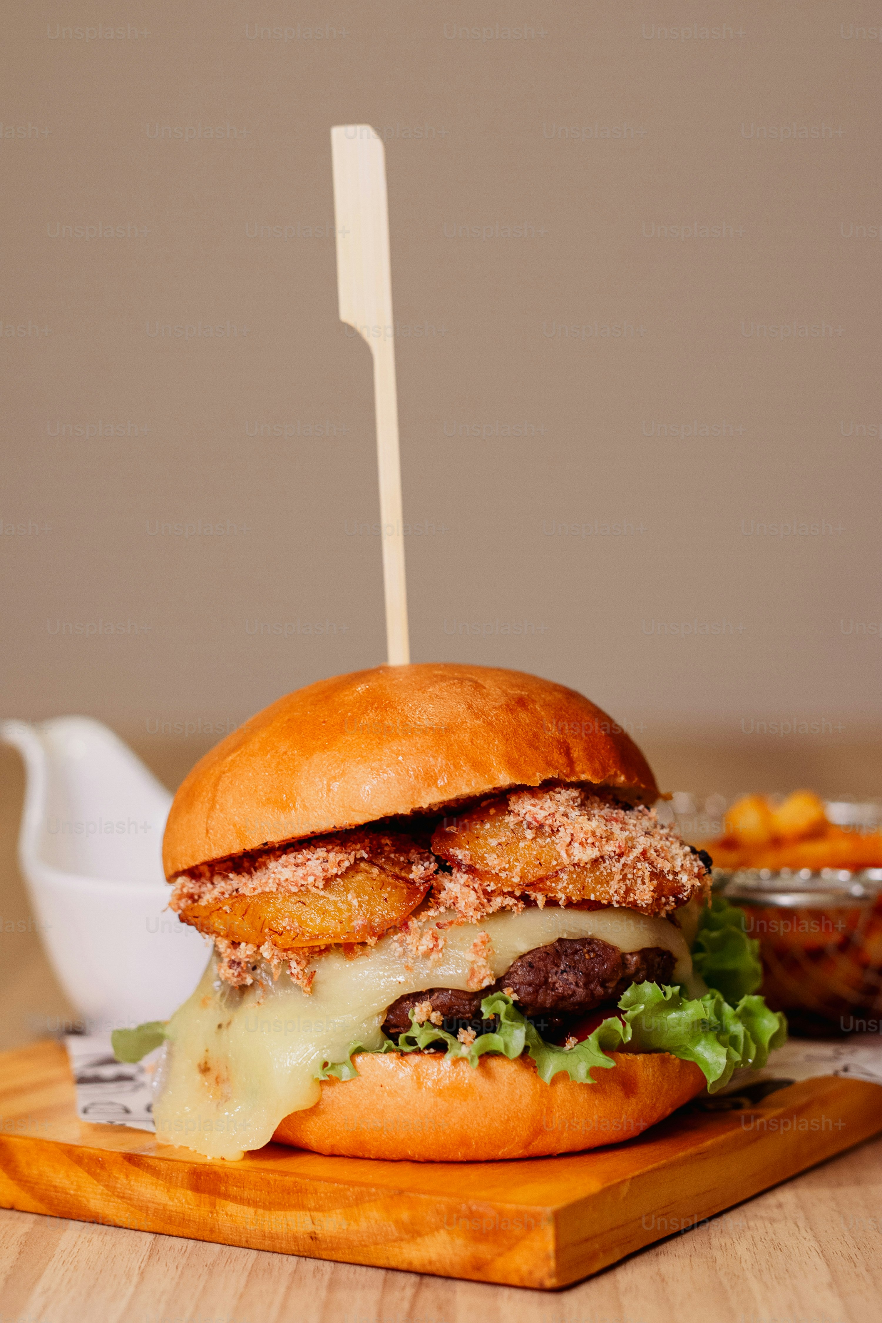 A cheeseburger on a cutting board with a toothpick sticking out of ...