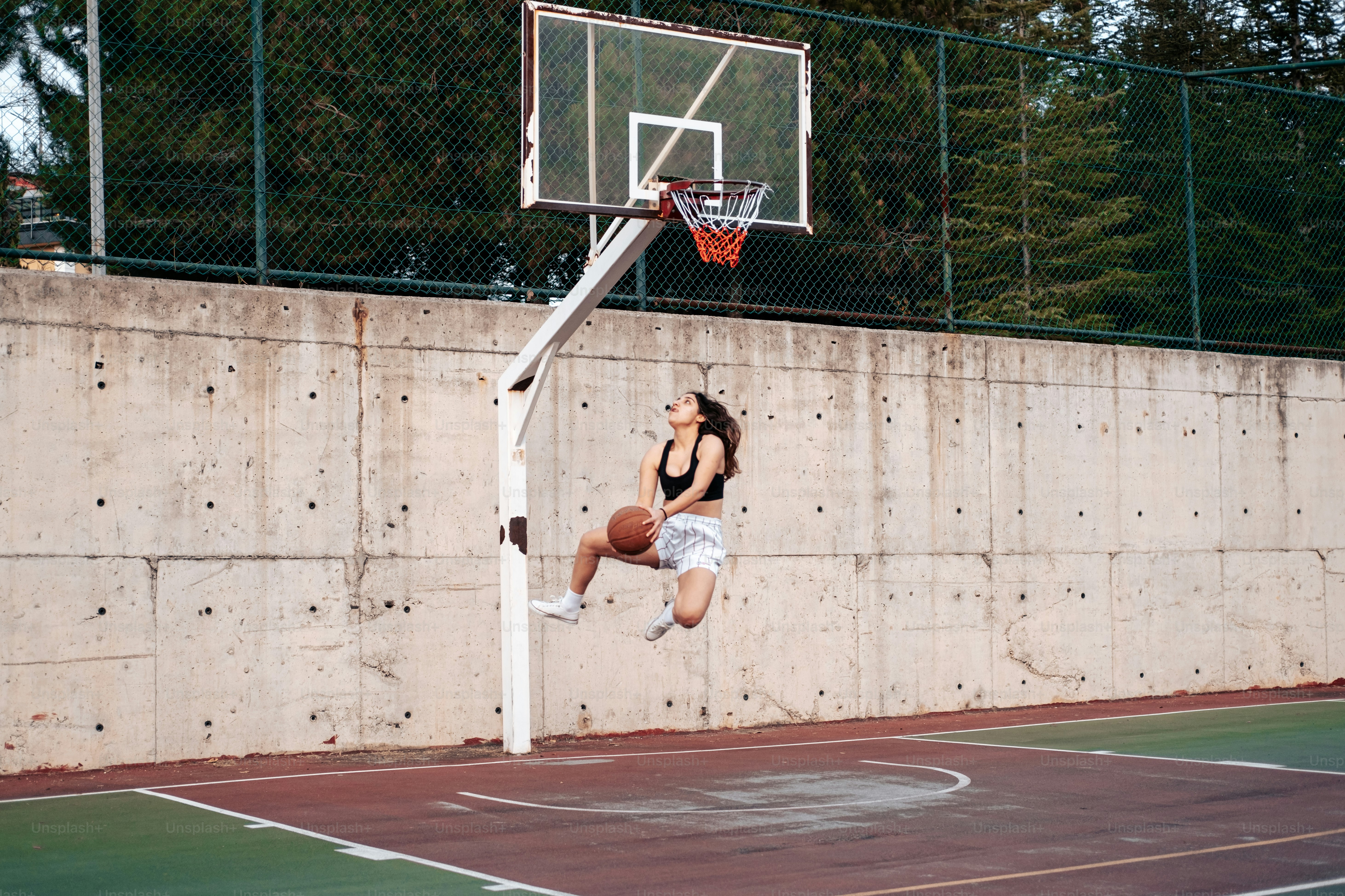 A person jumping up into the air to dunk a basketball photo – Agile ...