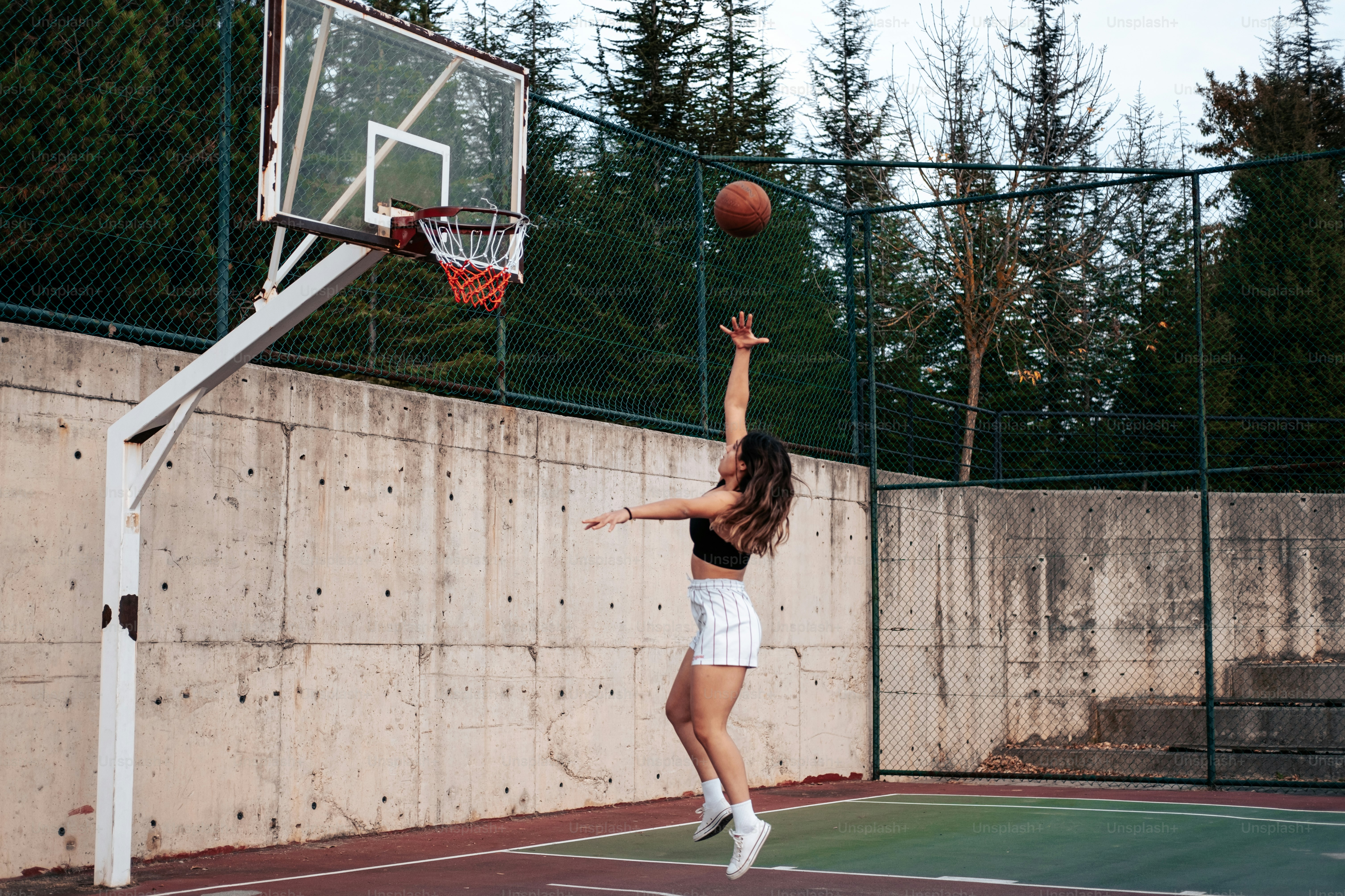 A woman jumping up to dunk a basketball photo – Basketball Image on ...