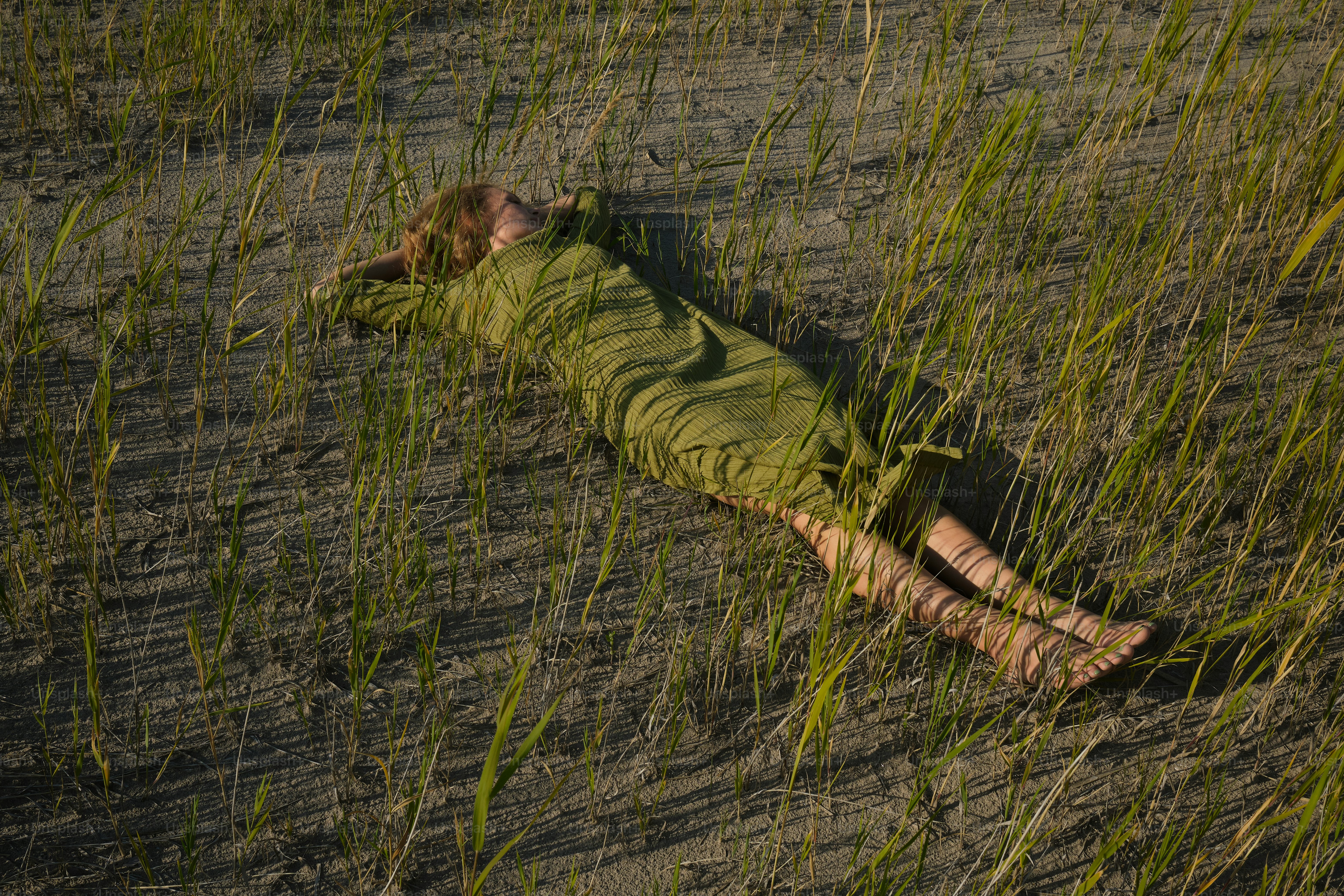 Foto Una persona acostada en un campo de hierba alta – Mujer Imagen en ...