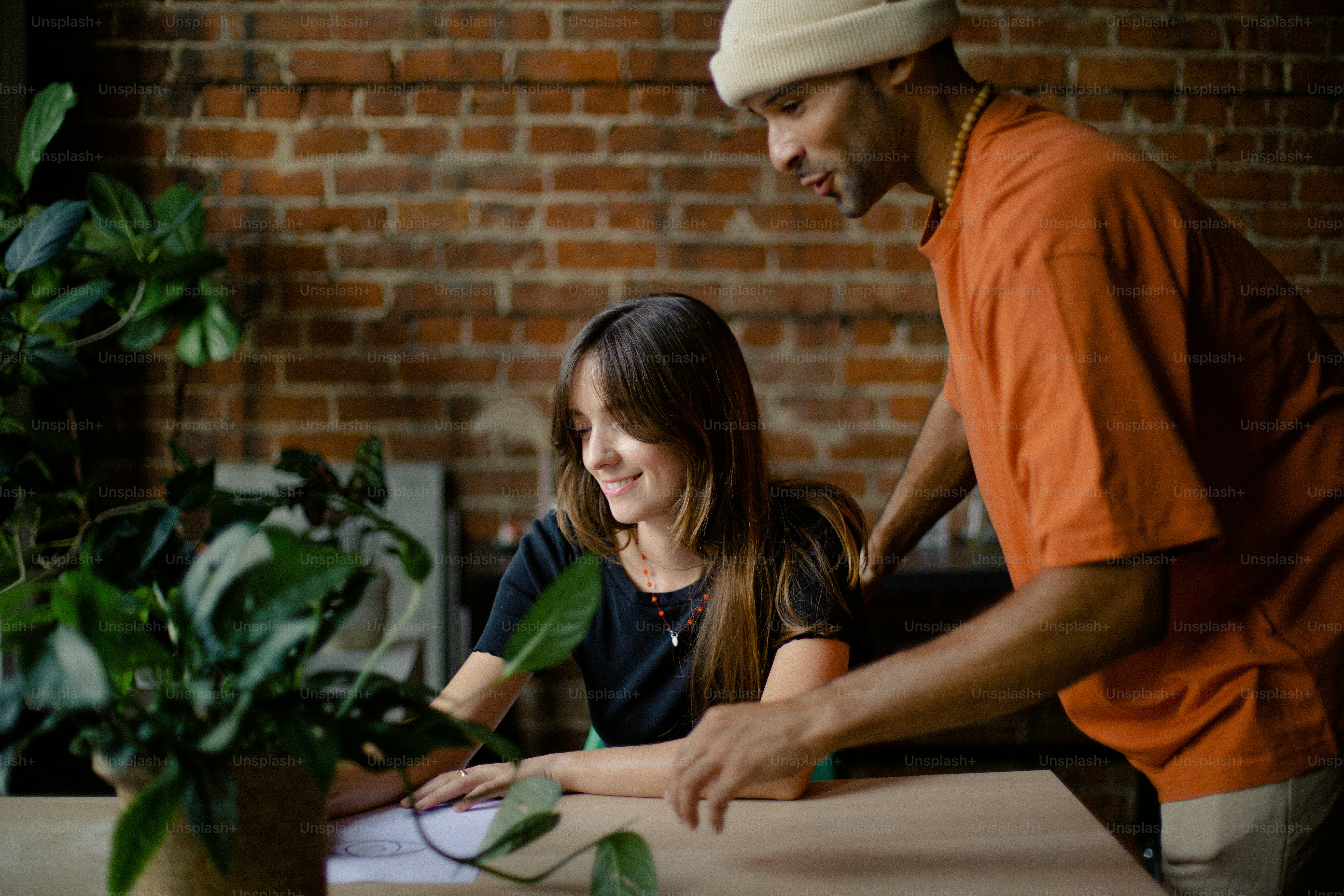 A man and a woman sitting at a table writing photo – Team Image on Unsplash