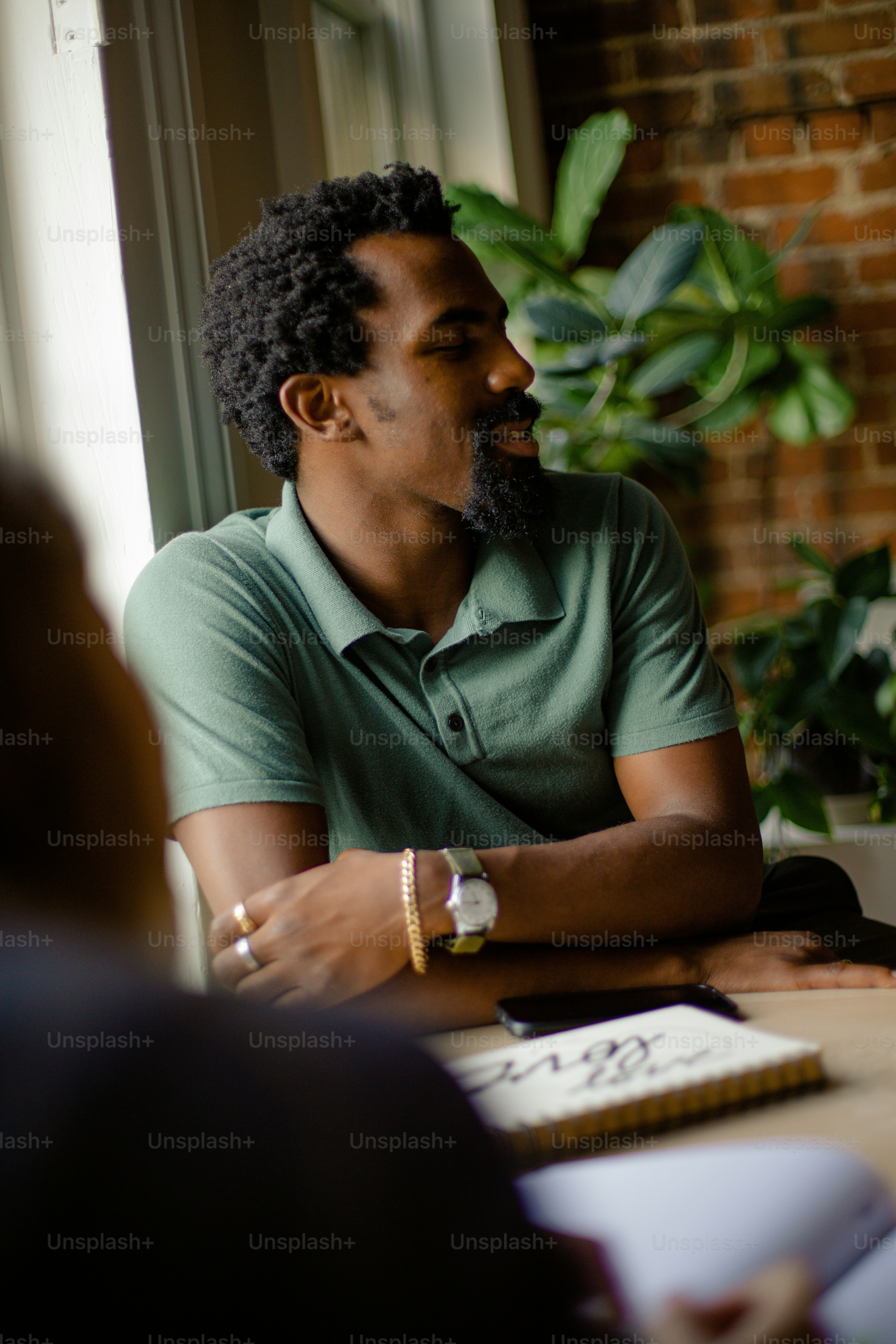 Un homme assis à une table devant une fenêtre photo – Travailler Photo ...