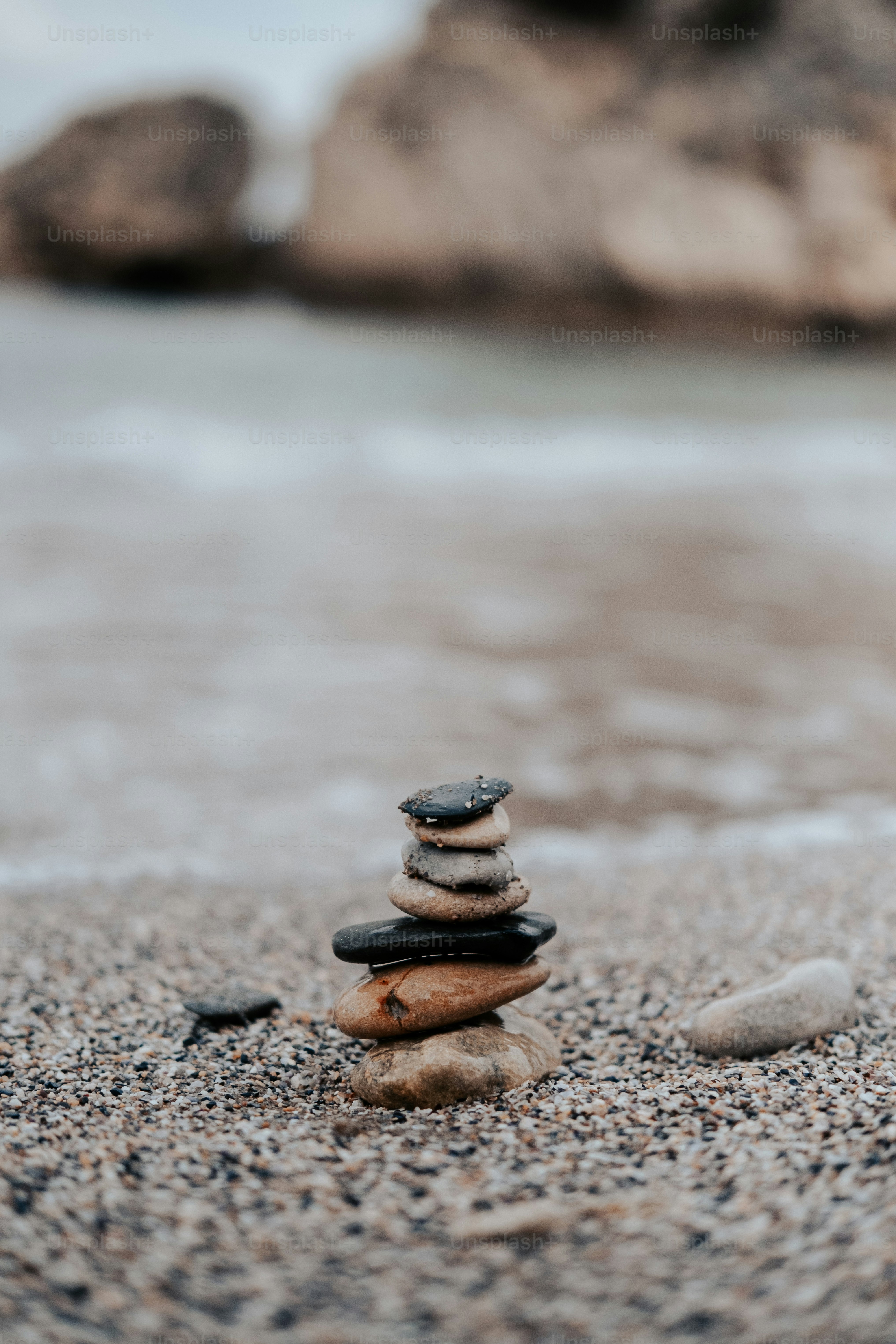 A stack of rocks sitting on top of a sandy beach photo – Cairn Image on ...