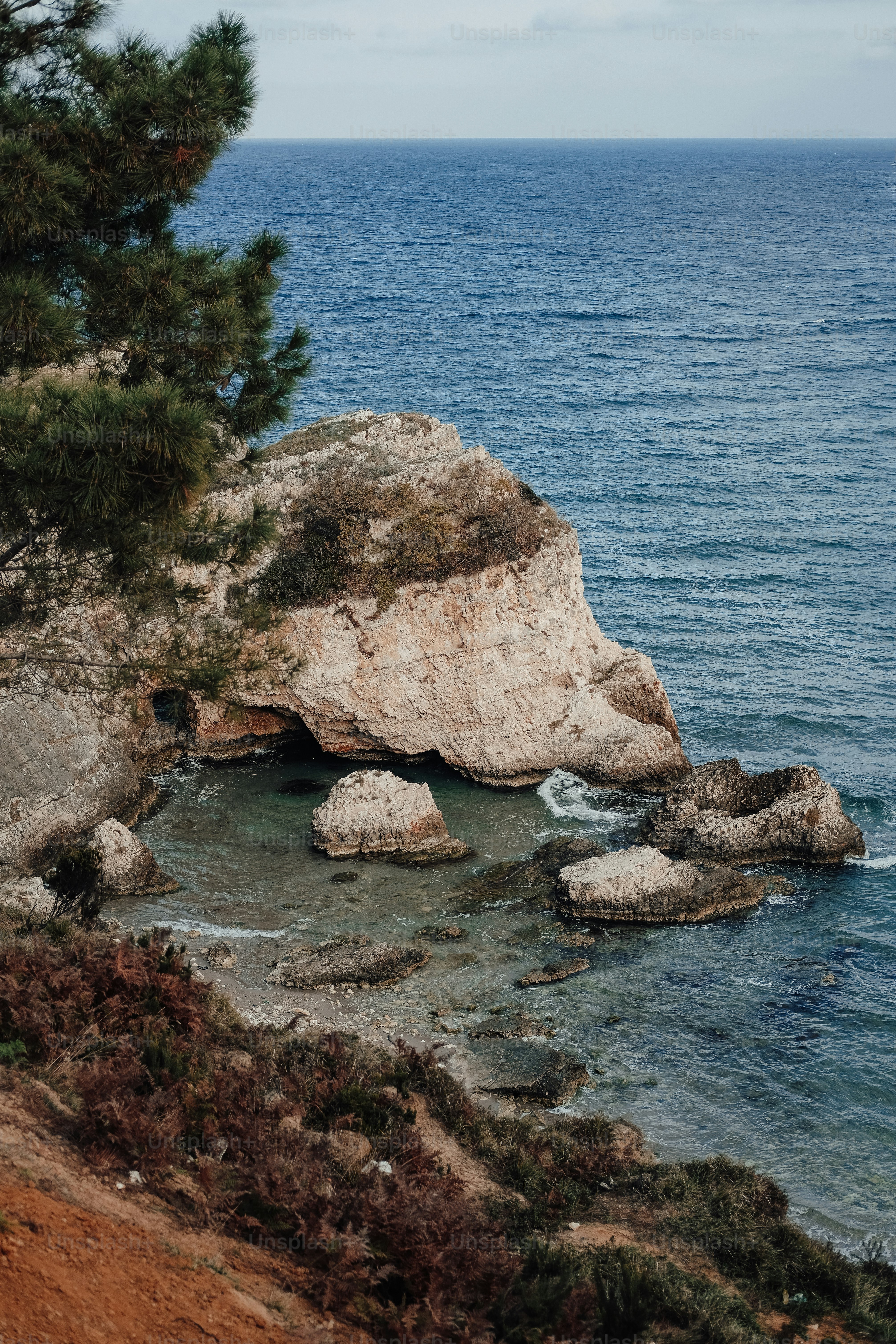 Un gros rocher assis au sommet d’une plage au bord de l’océan photo ...