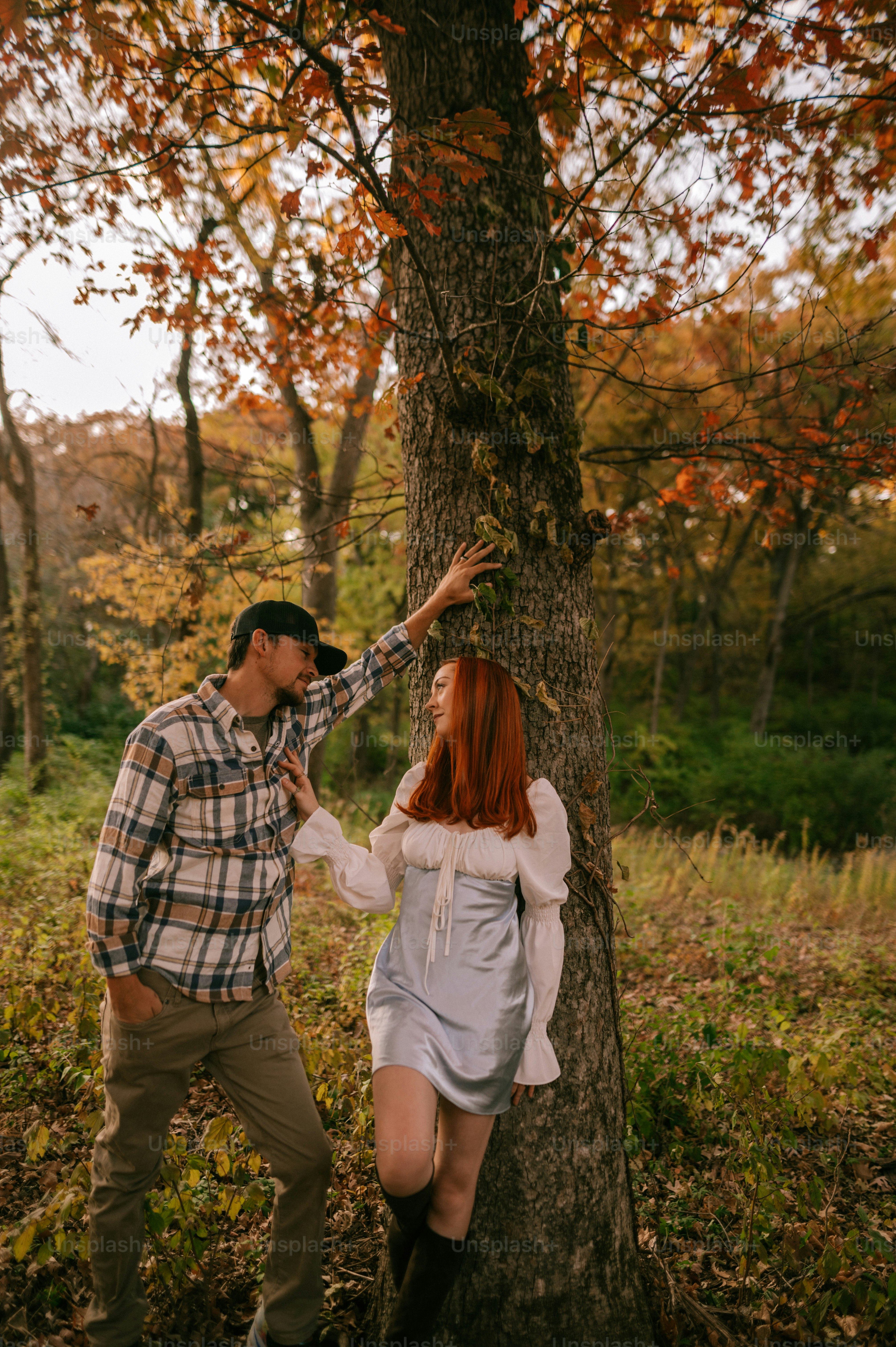 A man and a woman standing next to a tree photo – Tree Image on Unsplash