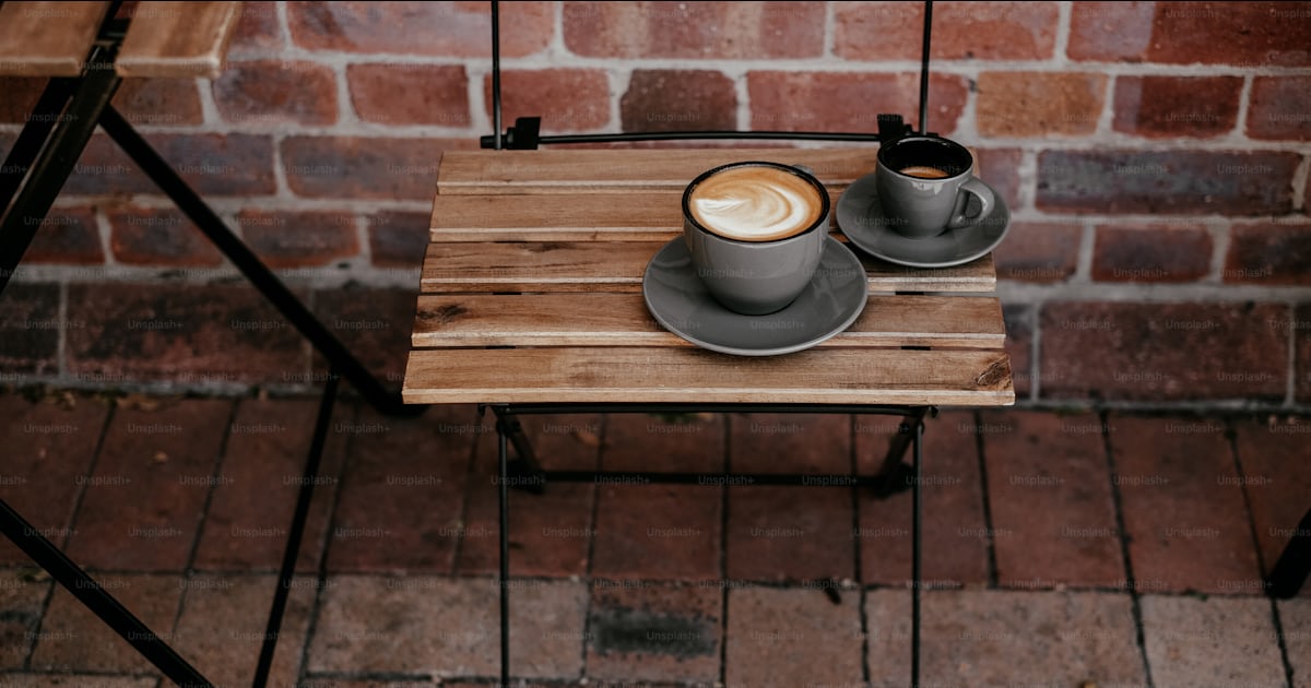 Une Table En Bois Surmontée De Deux Tasses De Café Photo Image De