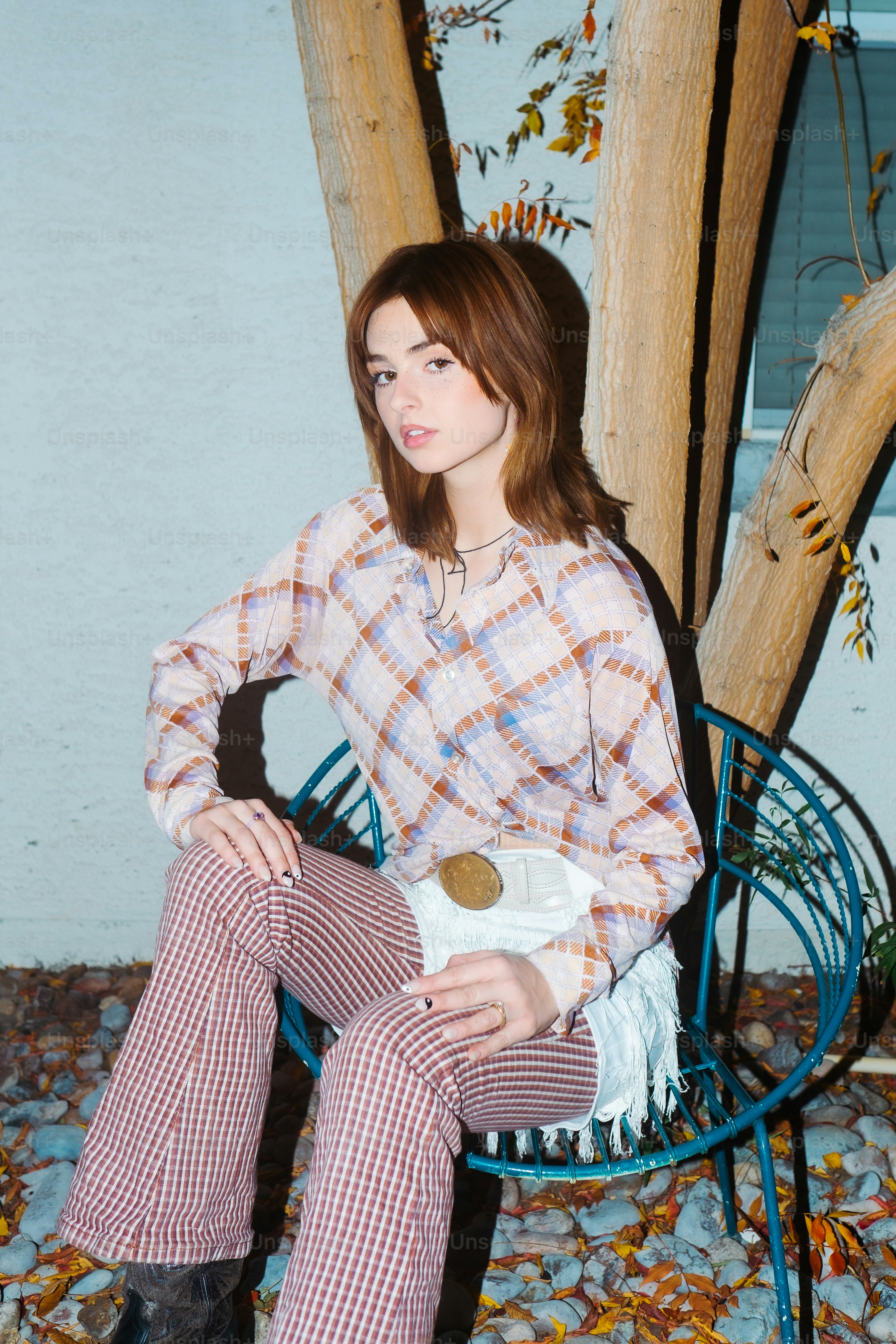 A woman sitting on a chair with her legs crossed photo – Fashion Image ...