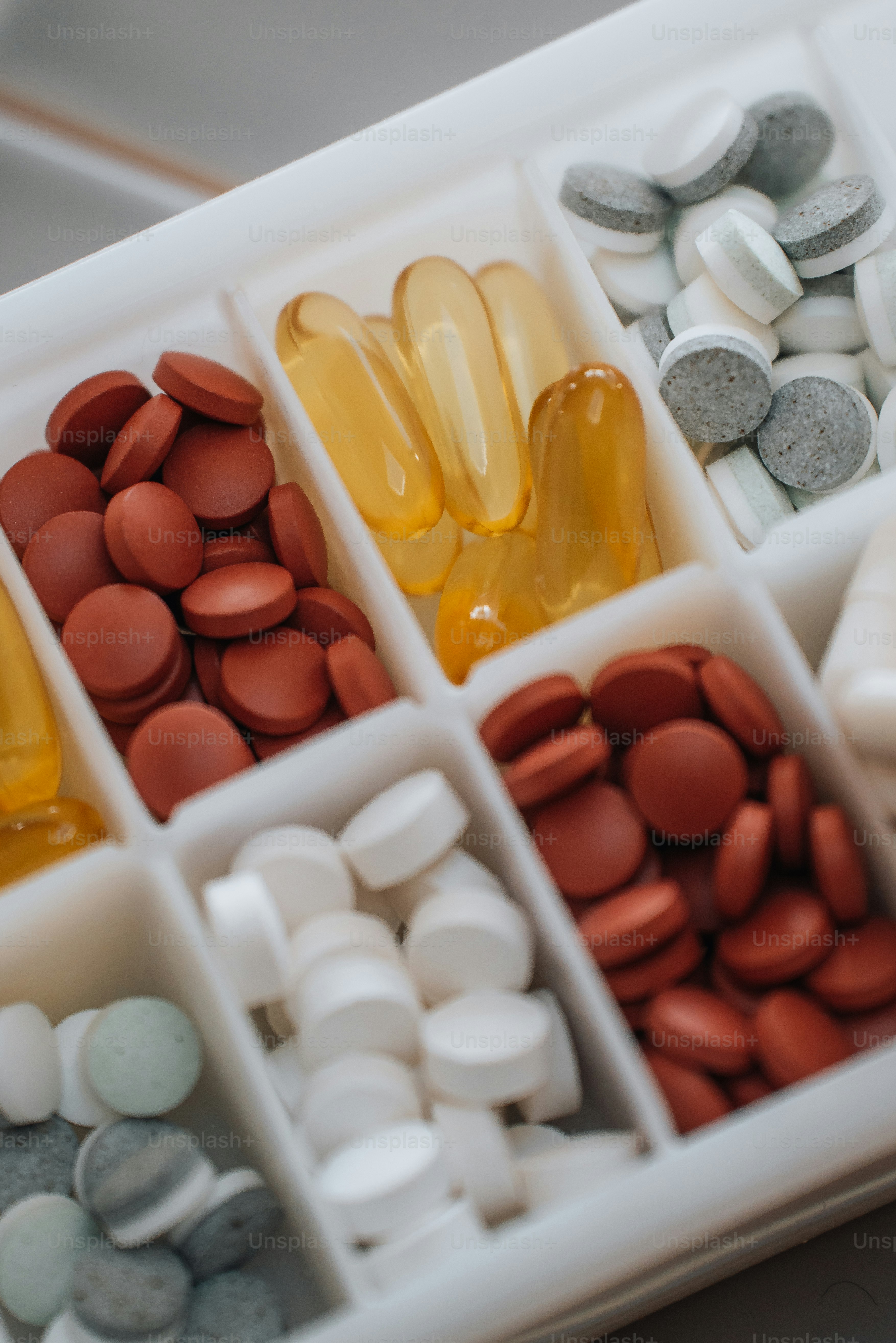 A pill tray filled with different colored pills photo – Drug Image on ...
