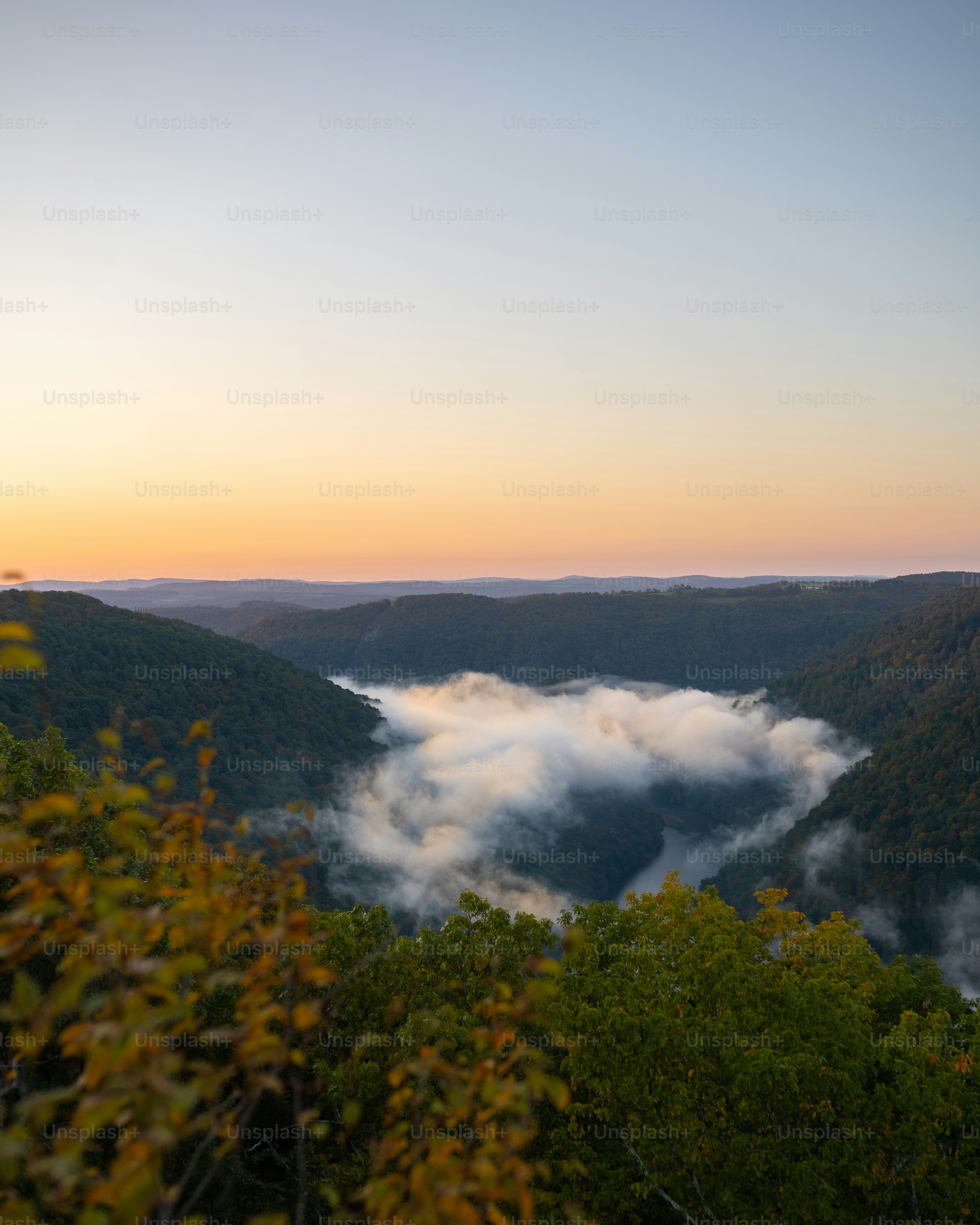 The sun is setting over a valley in the mountains photo – Landscape ...