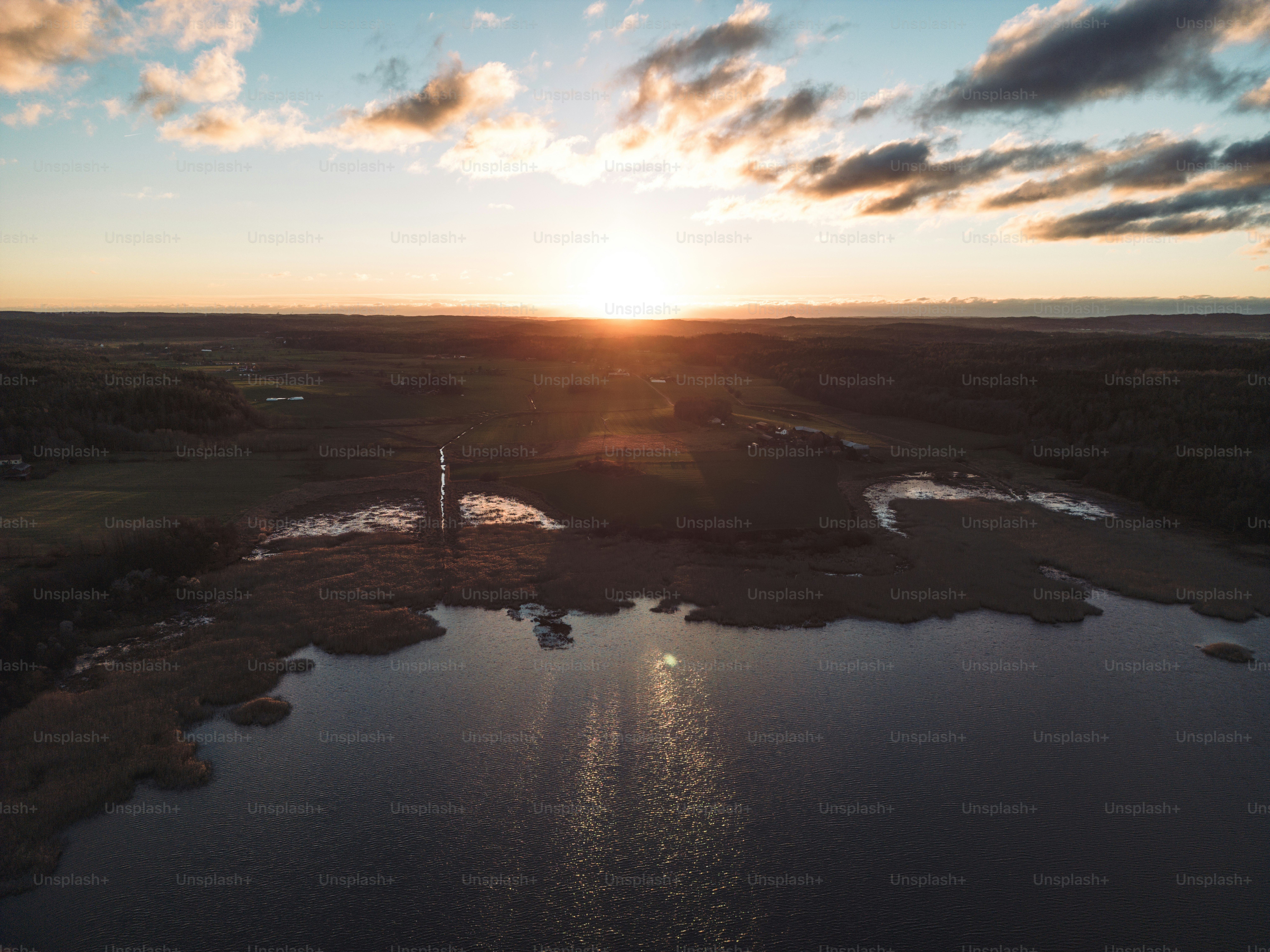 The sun is setting over a small lake photo – Sweden Image on Unsplash
