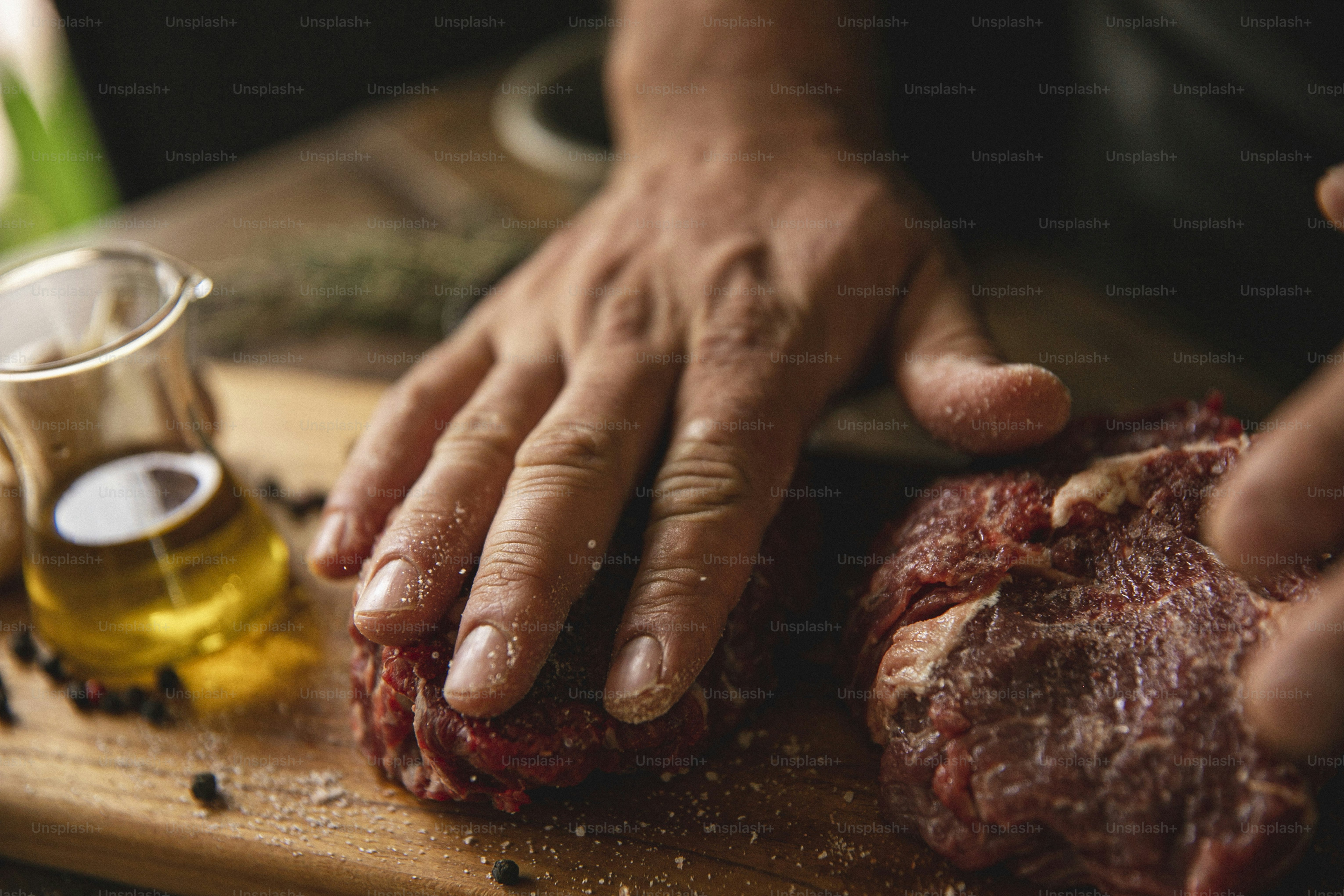 A person holding a piece of meat on a cutting board photo – Loin Image ...
