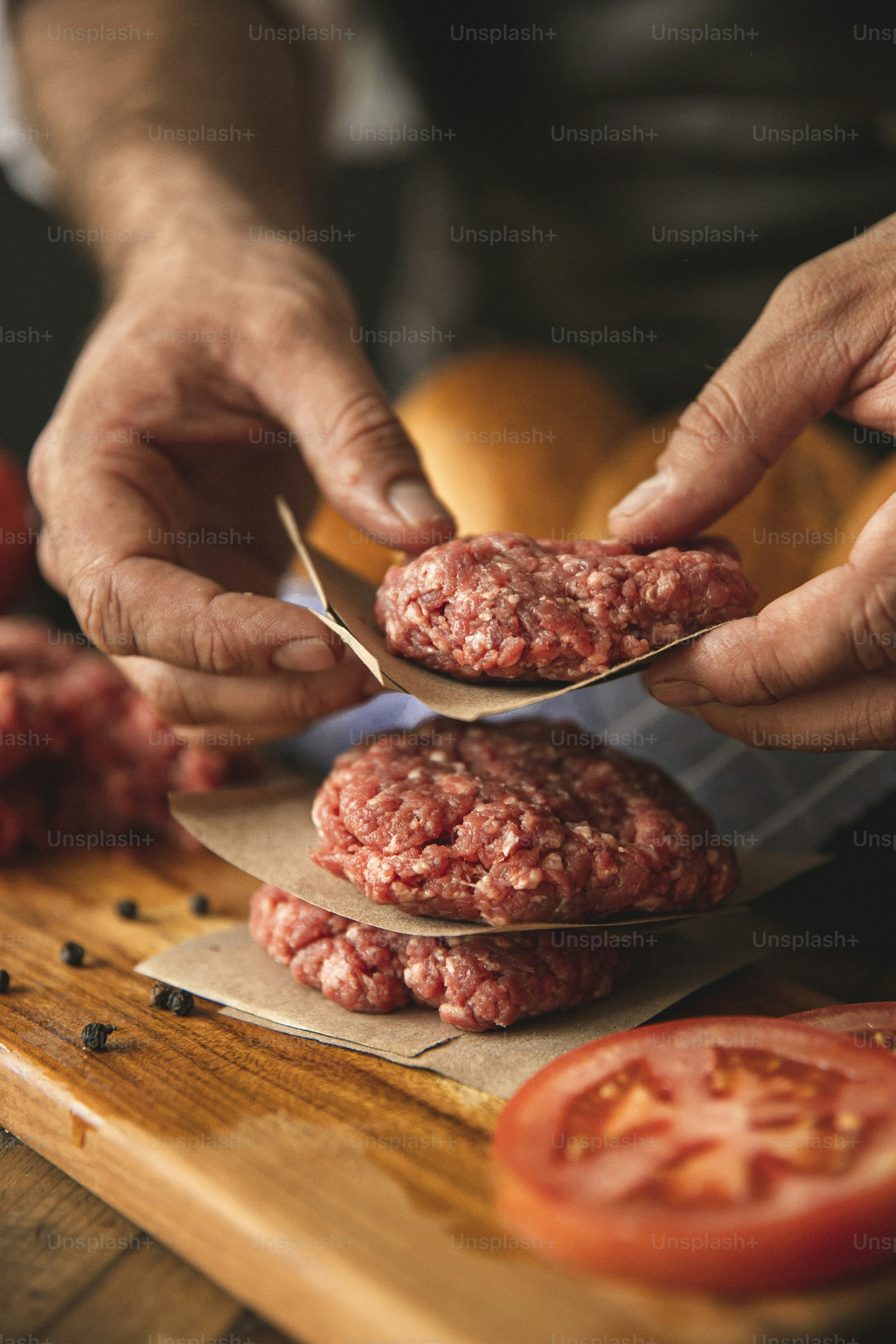 A person cutting up hamburger patties on a cutting board photo – Minced ...